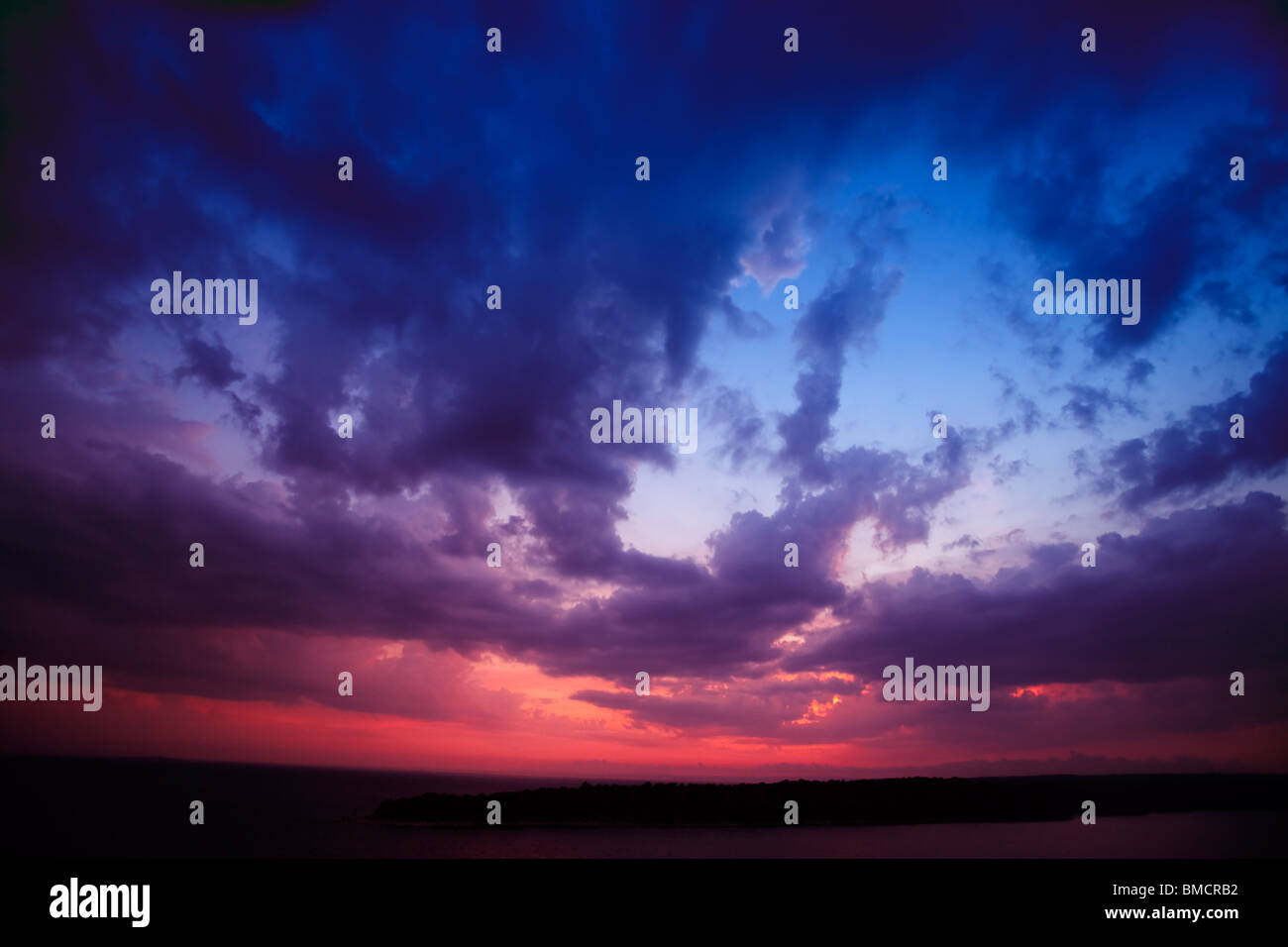 A dark landscape at sunset over the ocean Stock Photo - Alamy
