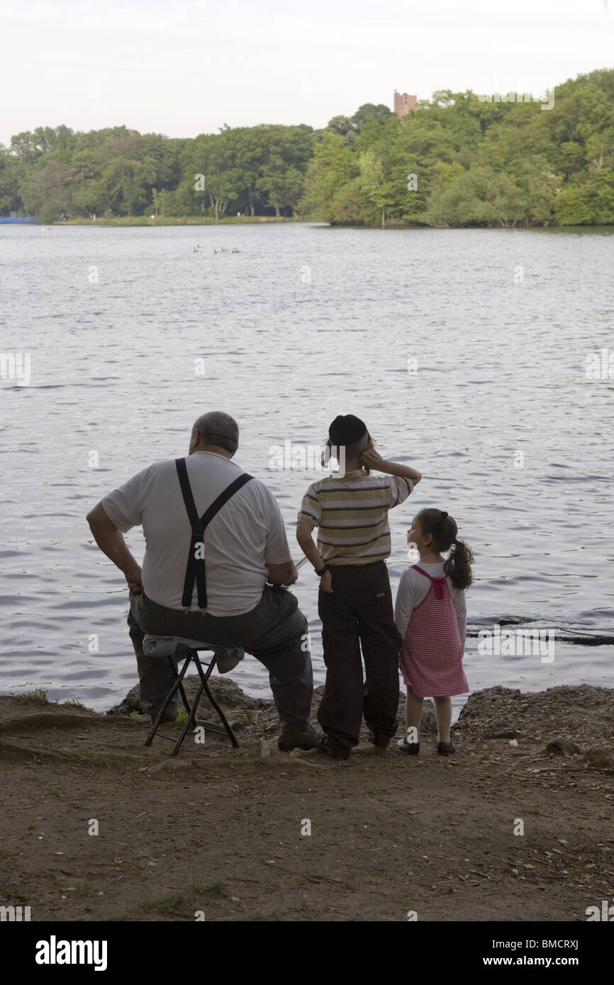 Orthodox Jewish children watch a man fishing on the lake in Prospect ...
