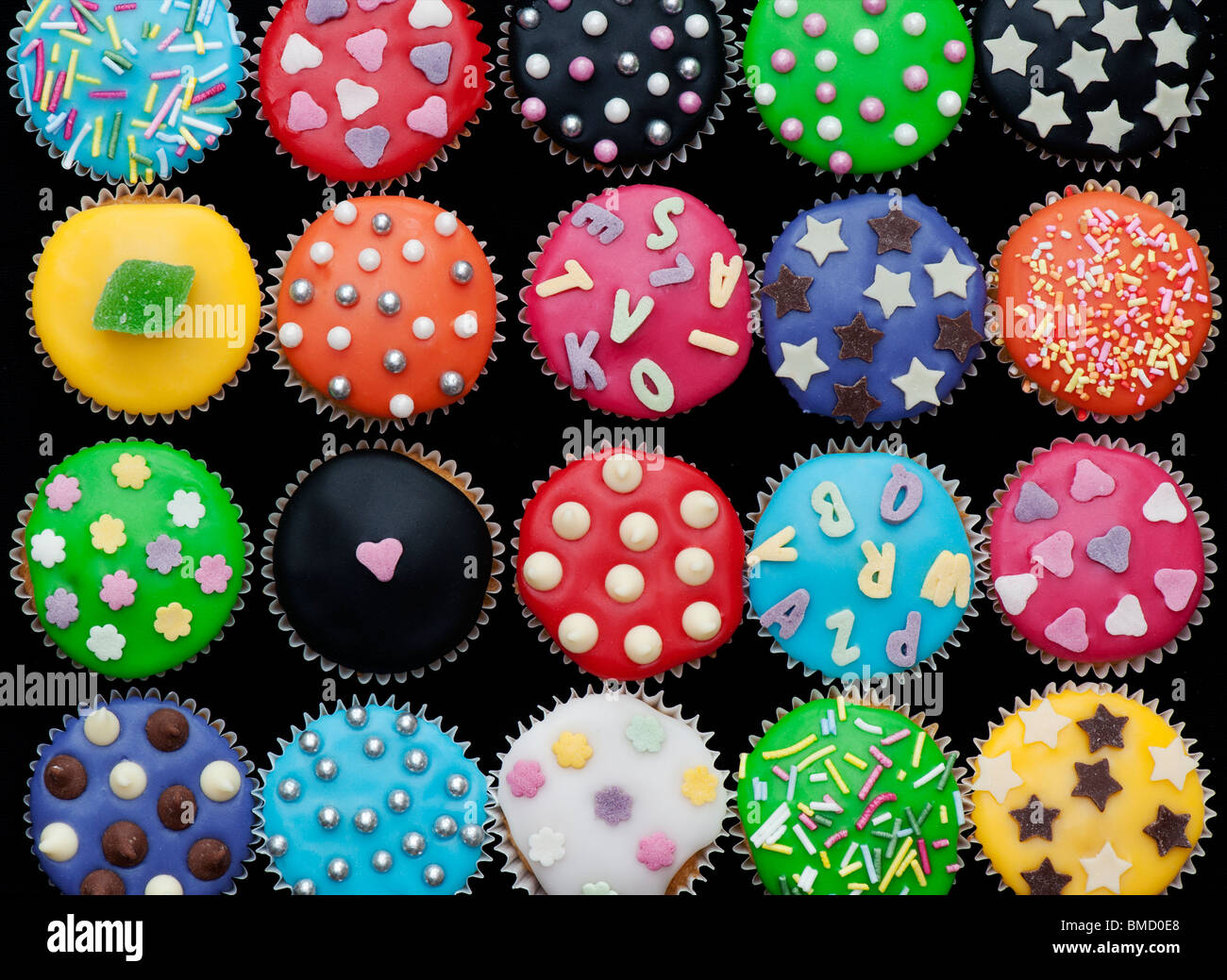 Colourful mini cupcakes on a black background Stock Photo - Alamy