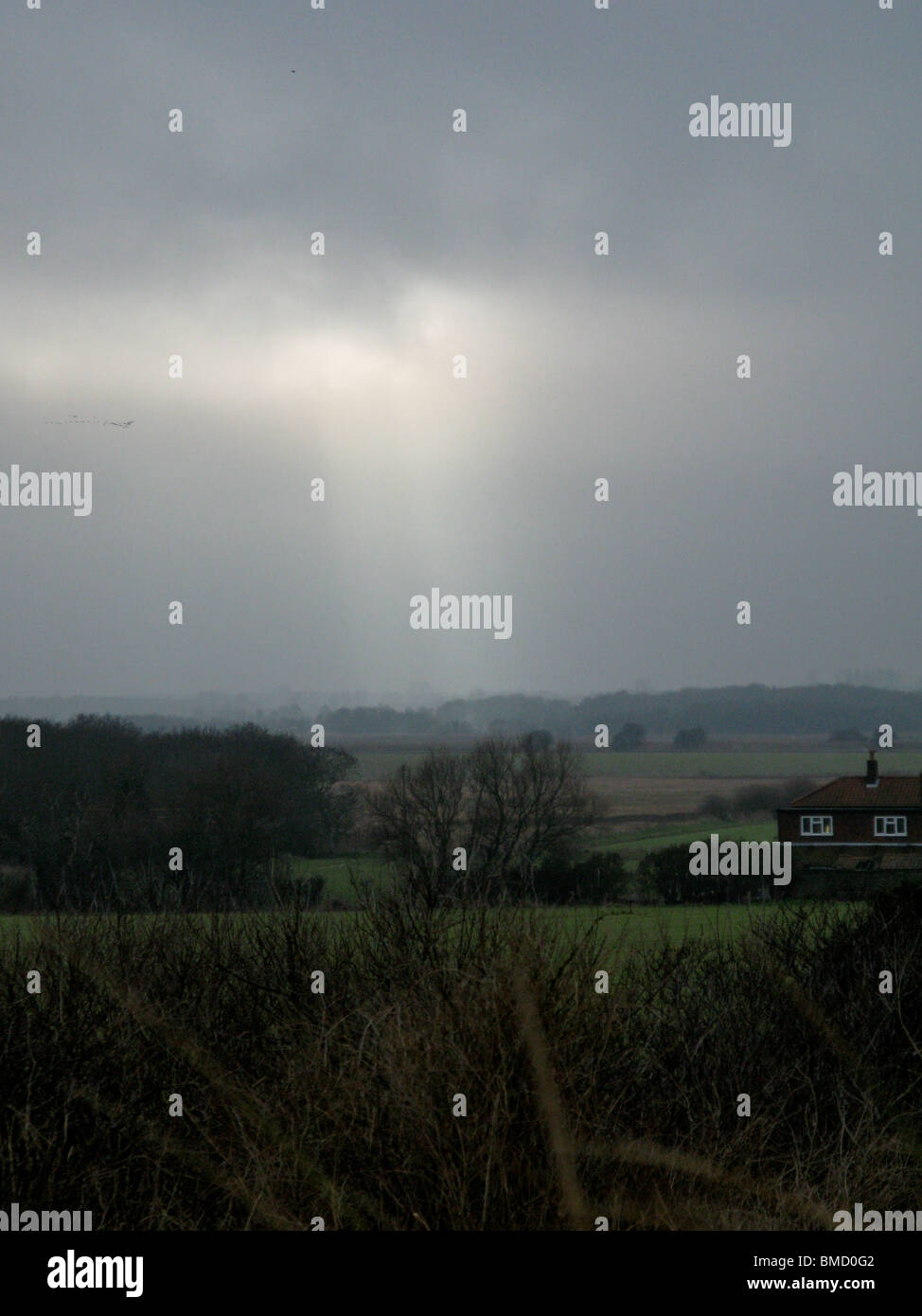 The sun penetrates the clouds, shining a ray of light on the windswept ...