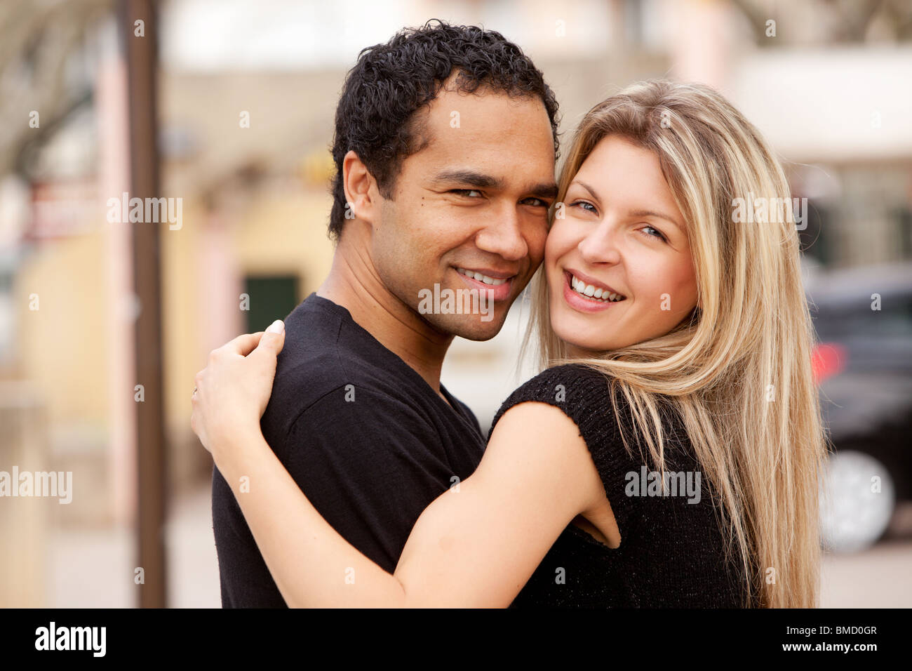 A happy couple hugging and looking at the camera Stock Photo - Alamy