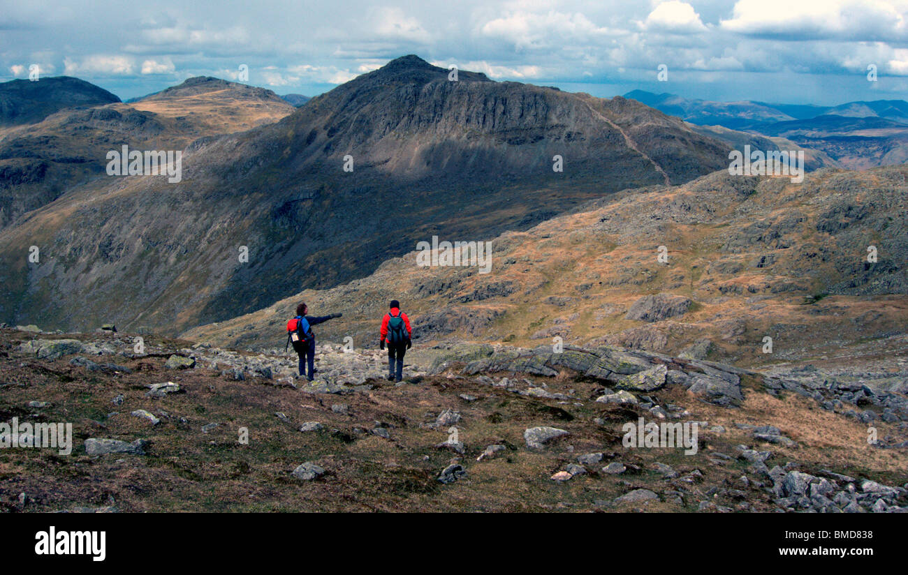 Two walkers heading towards Three Tarns and Bow Fell, Lake District ...