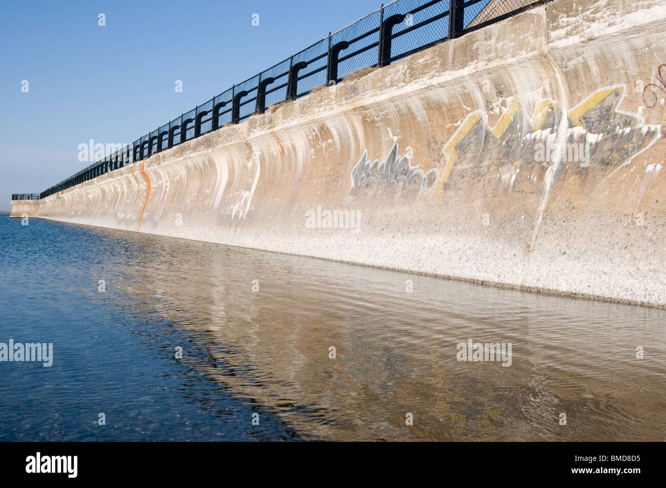 Sea Wall with railing on top Stock Photo - Alamy