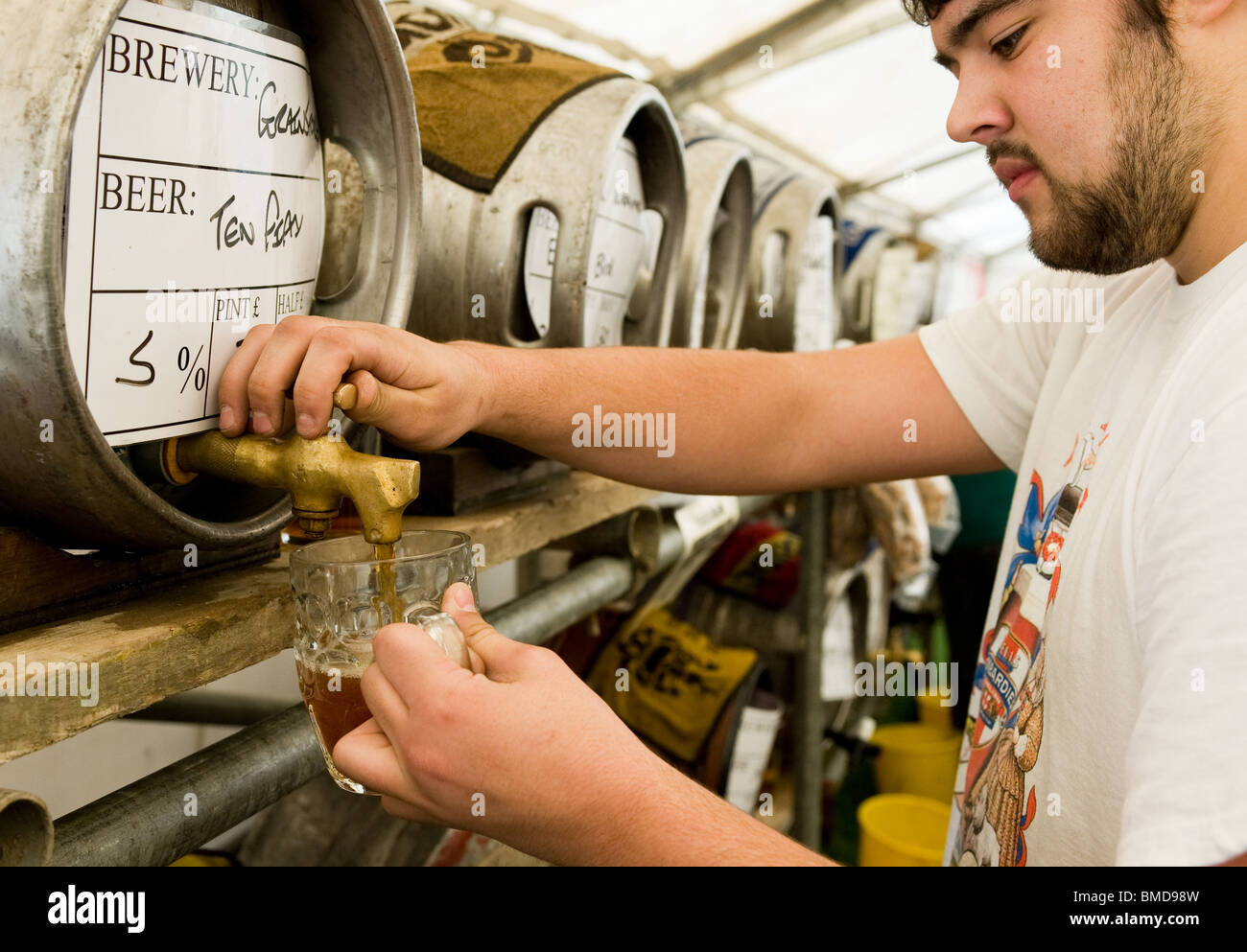 A bar worker pouring a pint of real ale at the Hoop Beer Festival in ...
