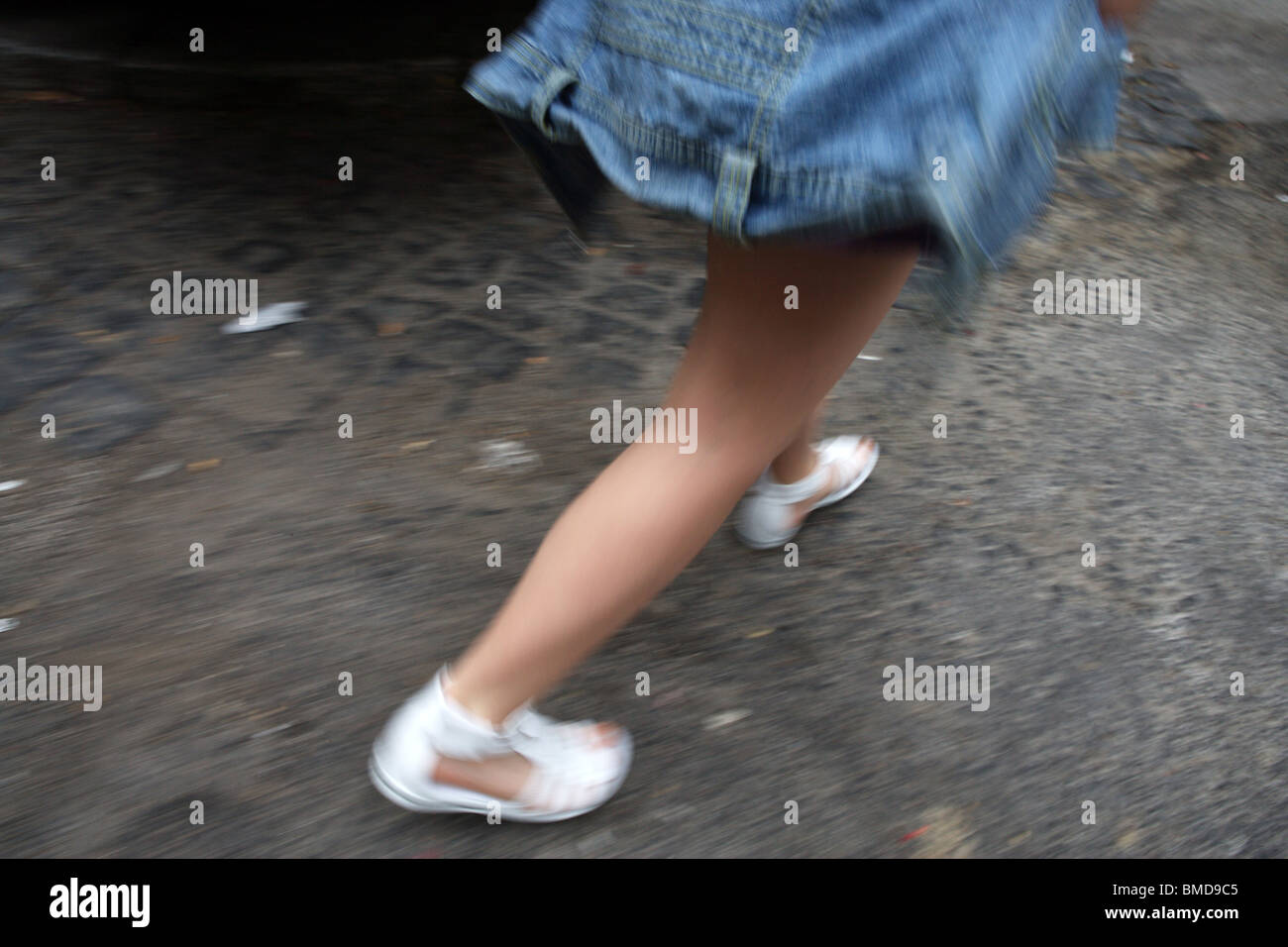 child girl running fast in the street of city town feet legs walking ...