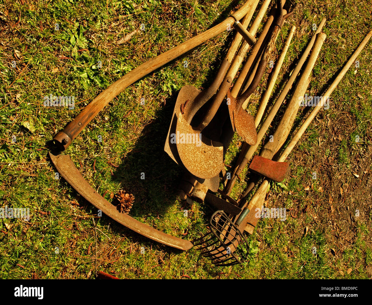 antique garden implements scythe hoe rake shovel on ground rusted Stock ...