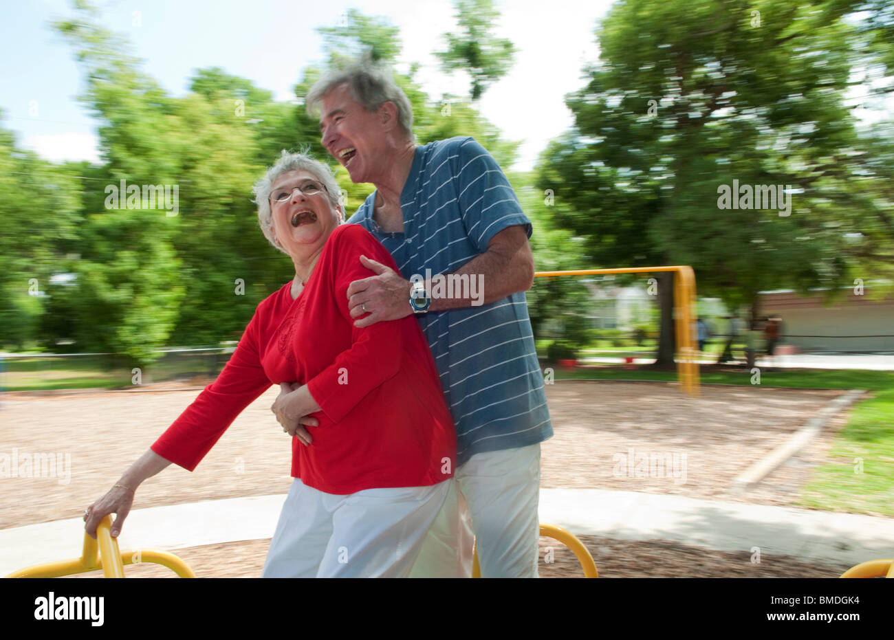 Attractive senior retired couple having fun in park on spin ride Stock ...