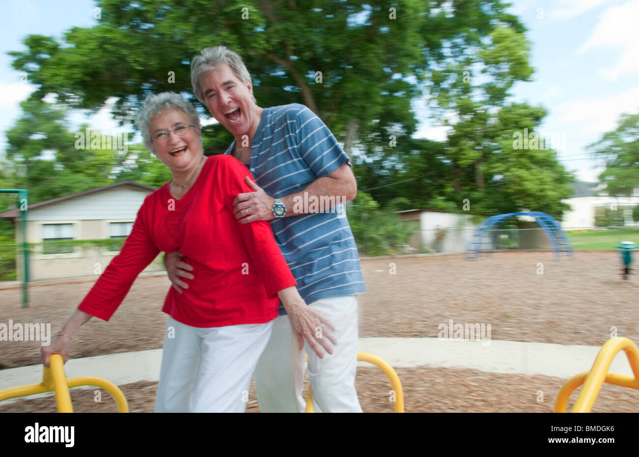 Attractive senior retired couple having fun in park on spin ride Stock ...