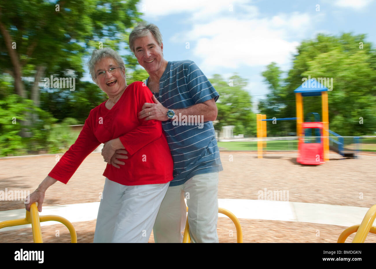 Attractive senior retired couple having fun in park on spin ride Stock ...