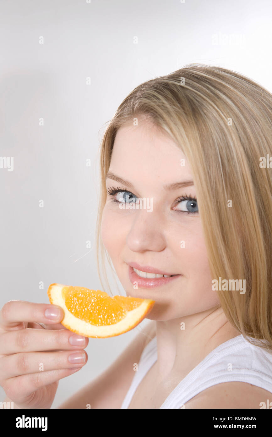 Woman Eating Slice of Orange Stock Photo - Alamy