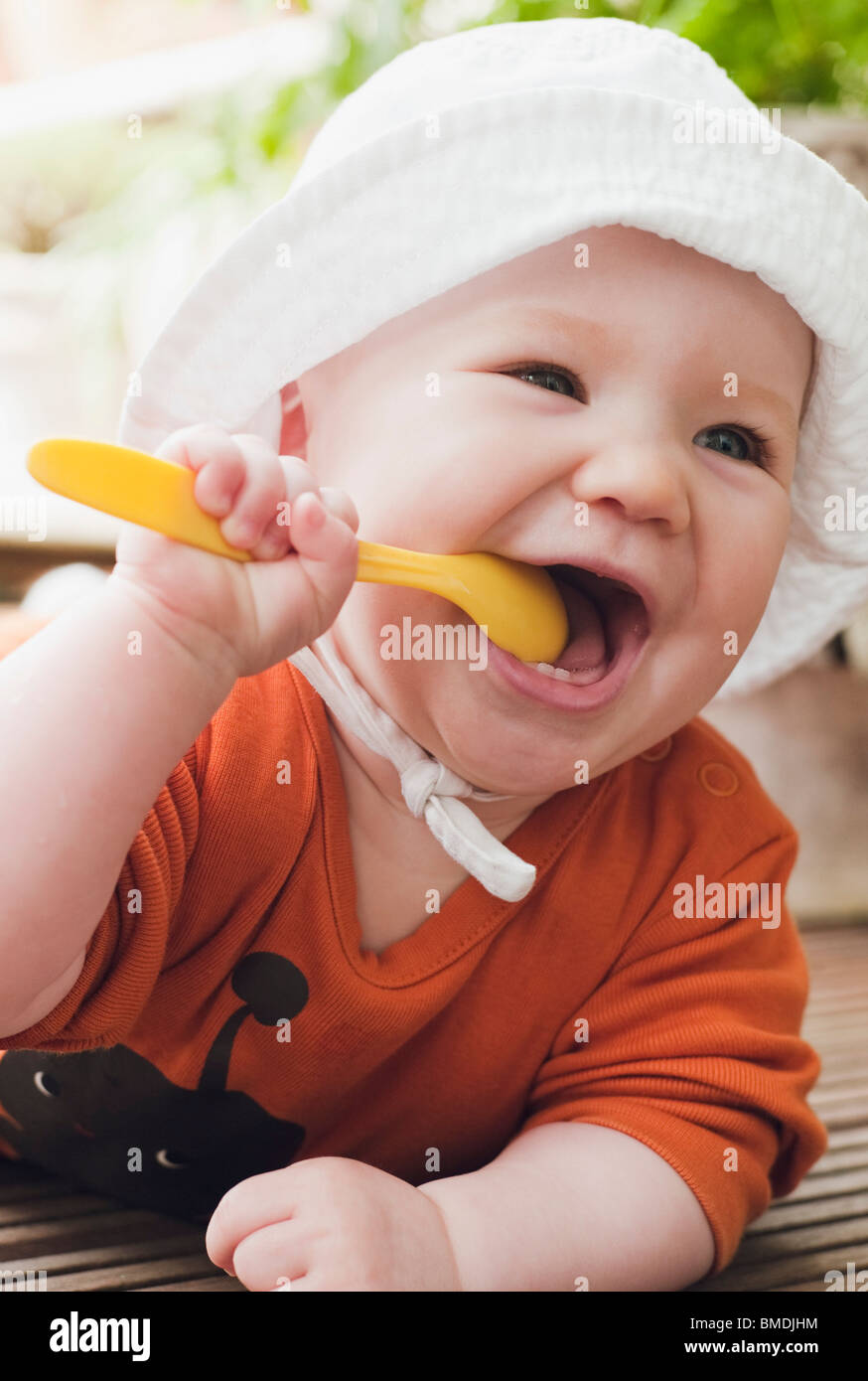 Baby Chewing on Plastic Spoon Stock Photo - Alamy