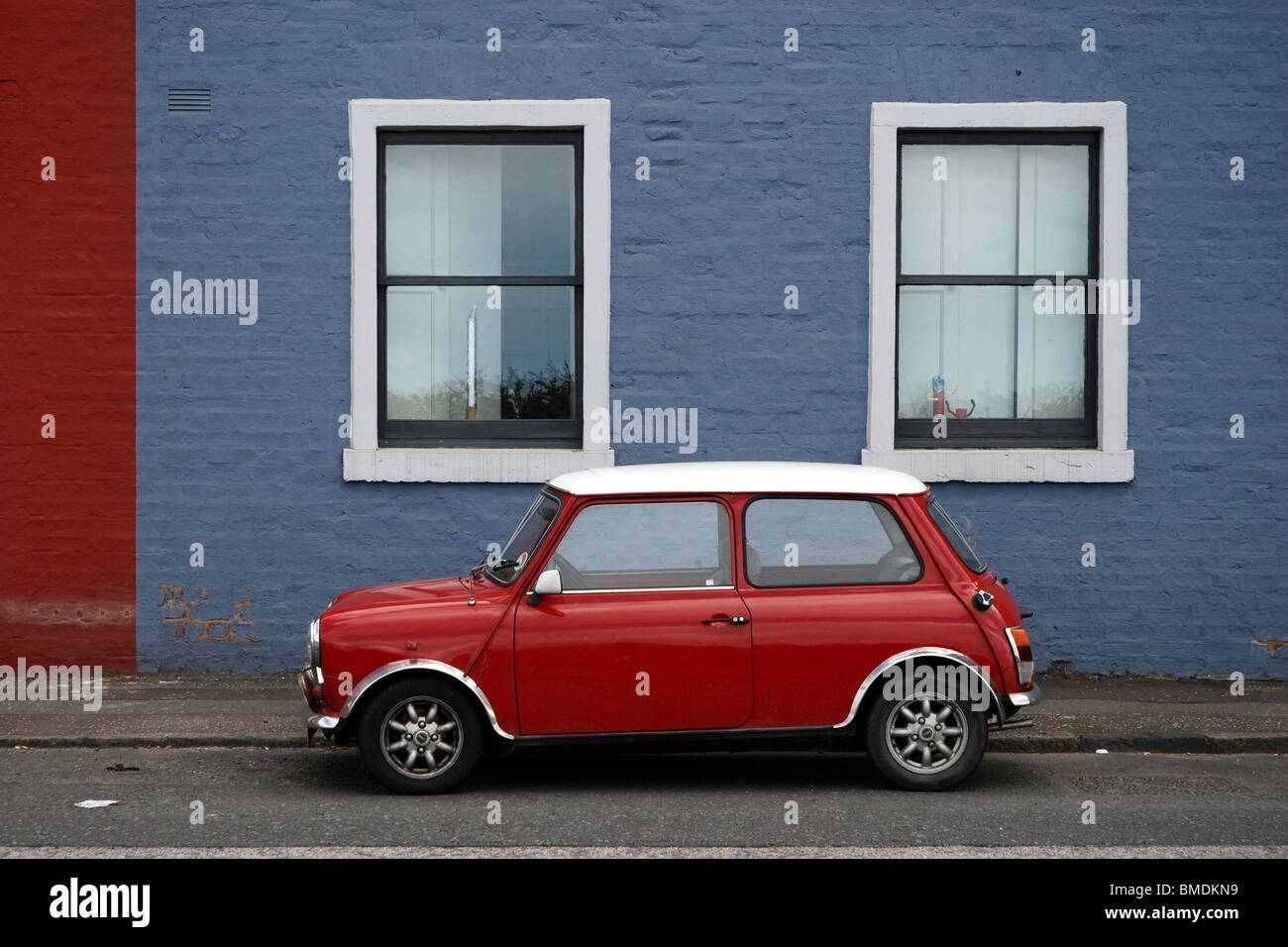 Classic red mini parked in front of a blue house Stock Photo - Alamy