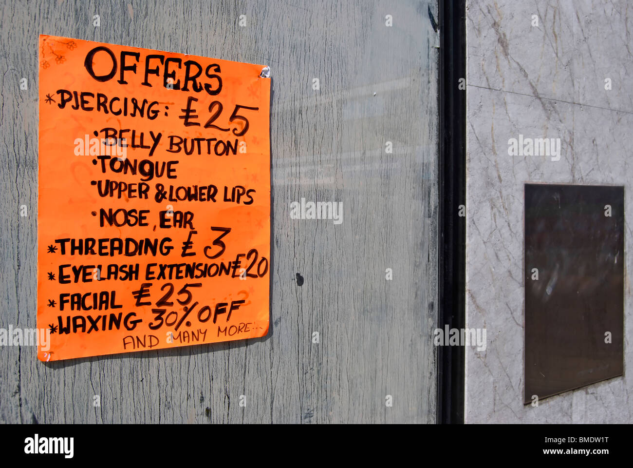 handwritten poster advertising body piercing, waxing, facials and more ...