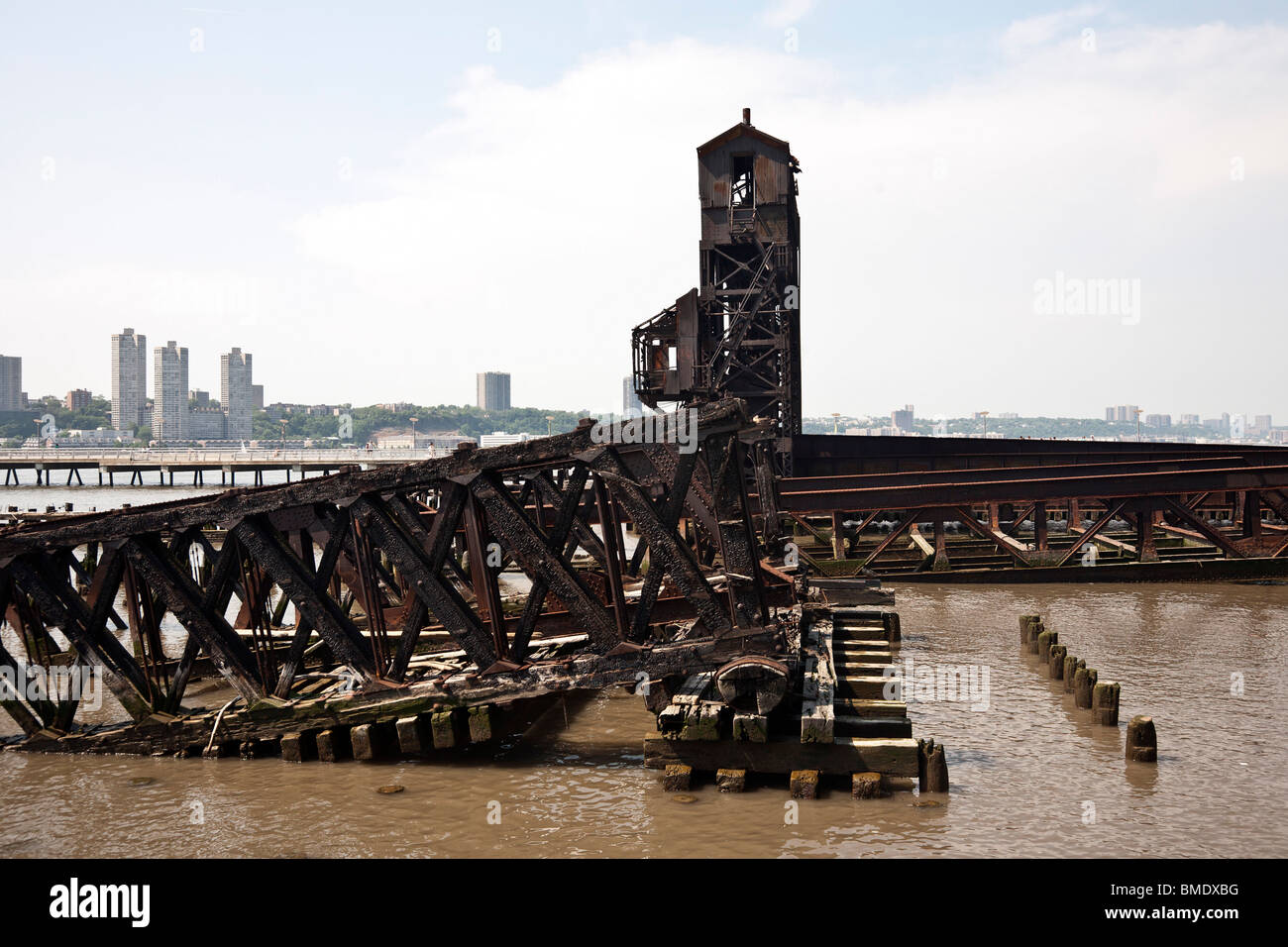 charred timber & rusted steel frame of burned out railway pier formerly ...