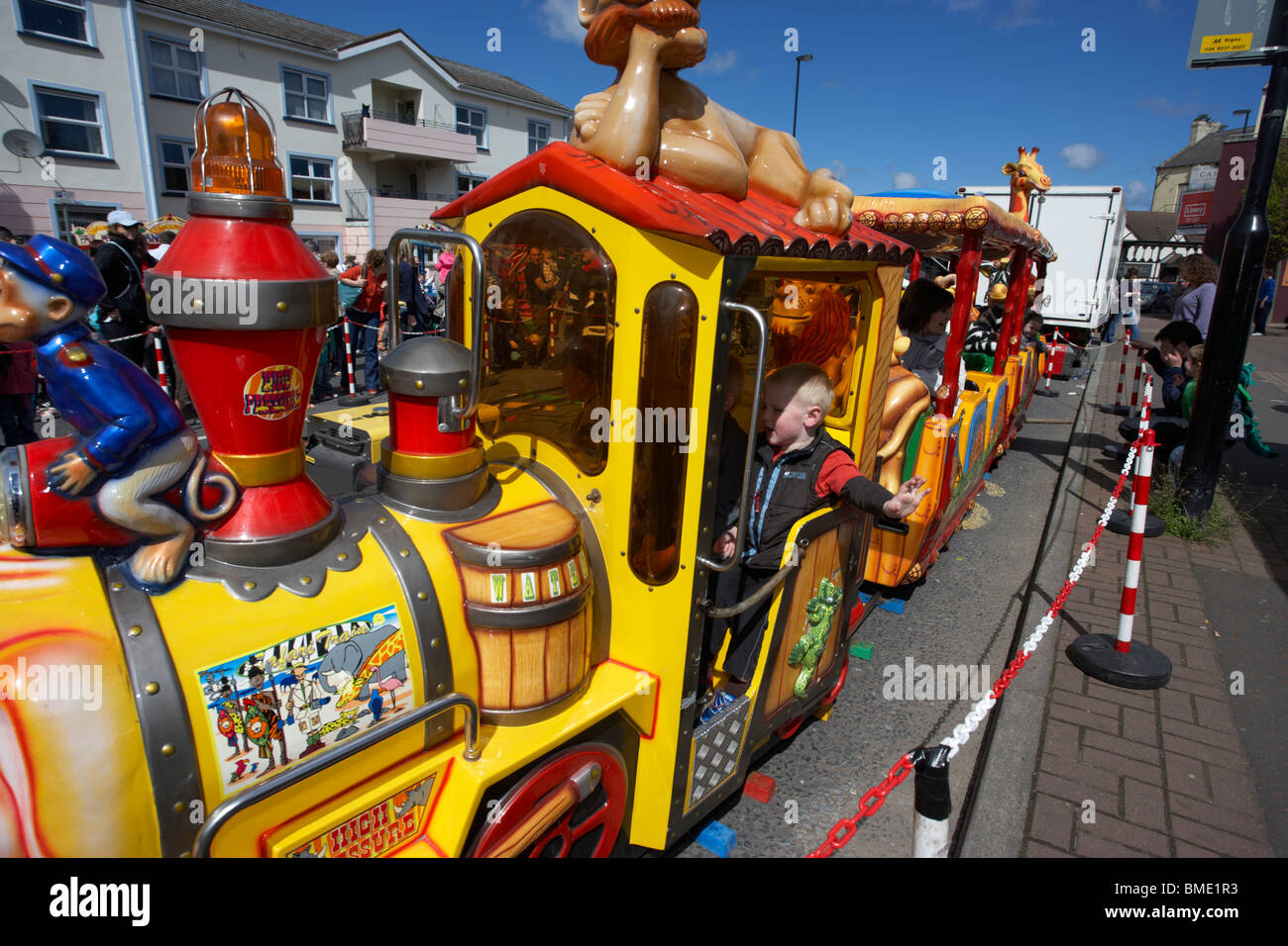 young children on a train ride at an outdoor funfair event on mayday in ...