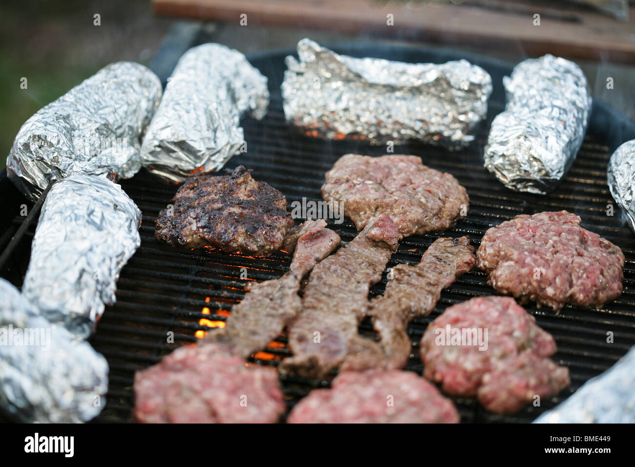 Various meats on a barbecue grill Stock Photo - Alamy