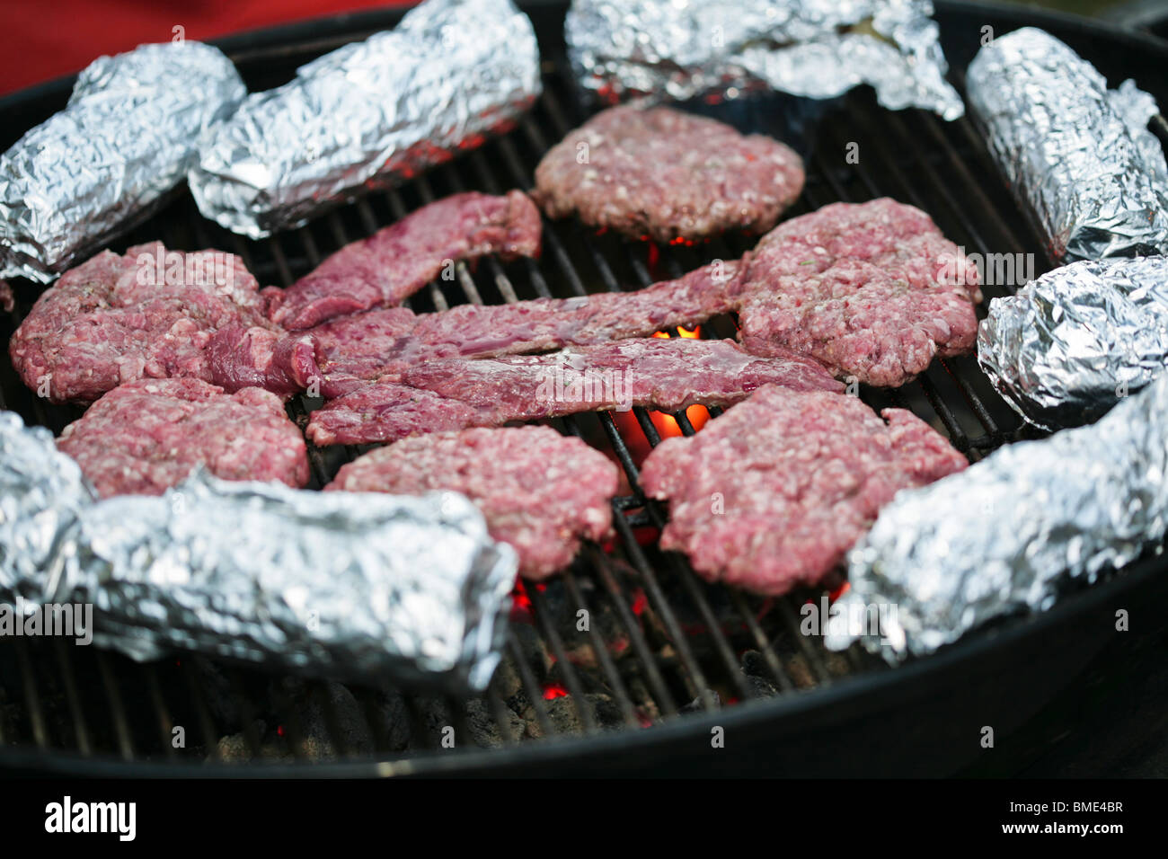 Various meats on a barbecue grill Stock Photo - Alamy
