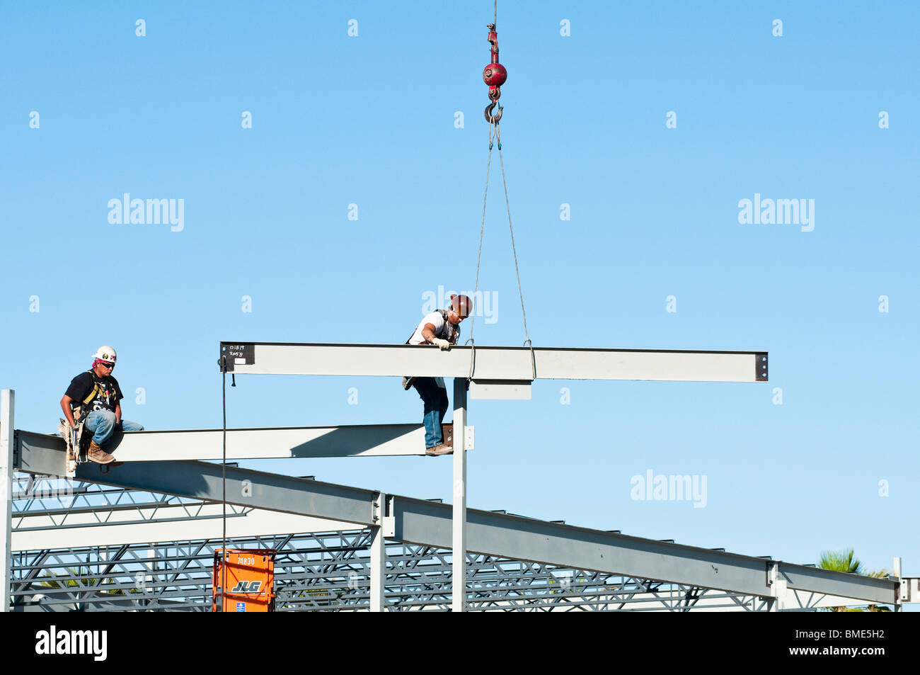 steelworkers erect the structural steel framework for a commercial ...