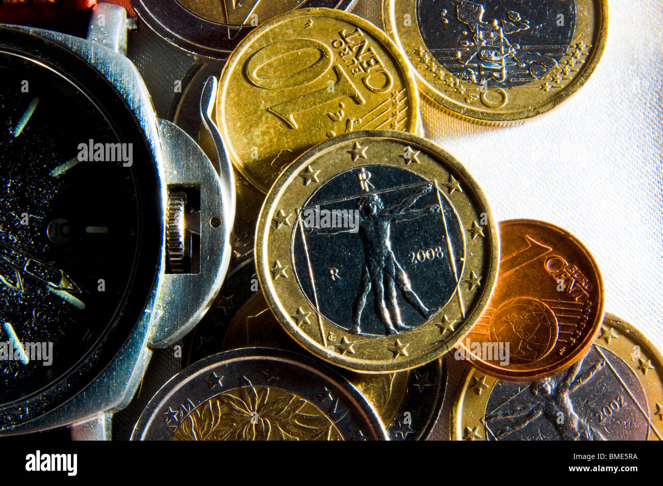 Macro of a clock euro coins with light grazing. Combination time ...