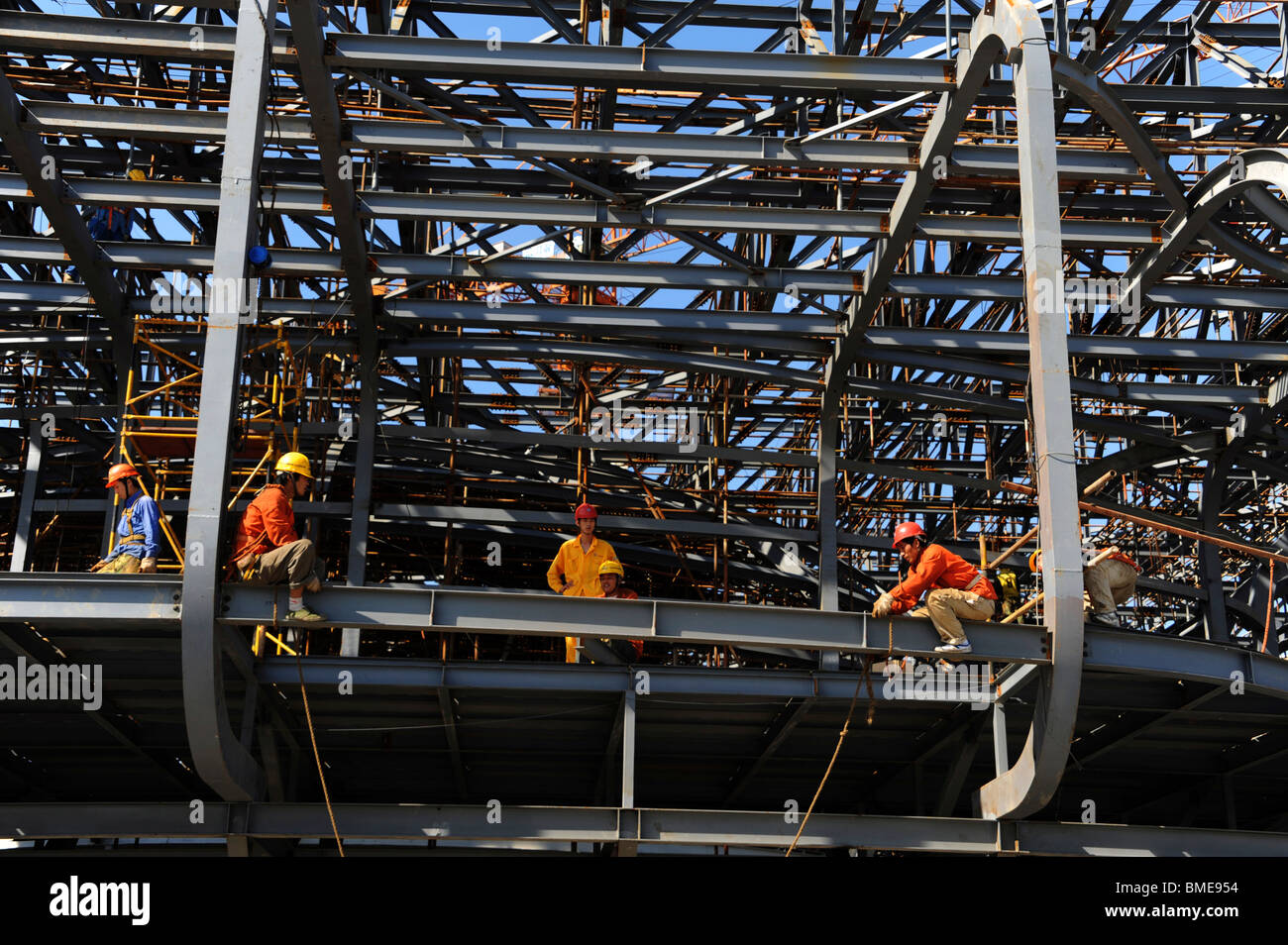Construction workers working on massive steel frame of an exhibition ...