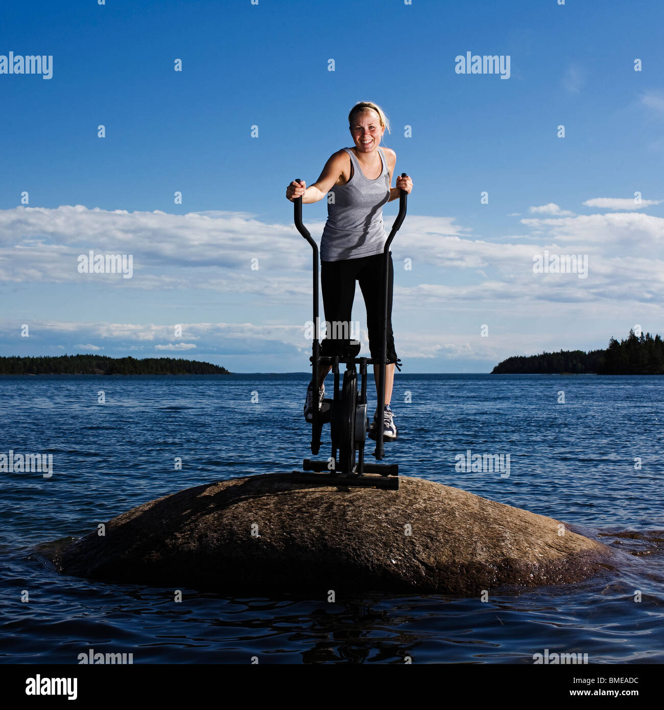 Young woman on a working out on a rock in a lake, Sweden Stock Photo ...