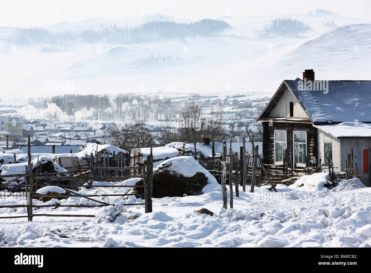 Snow covered wooden house in a large village, Oroqin Autonomous Banner ...