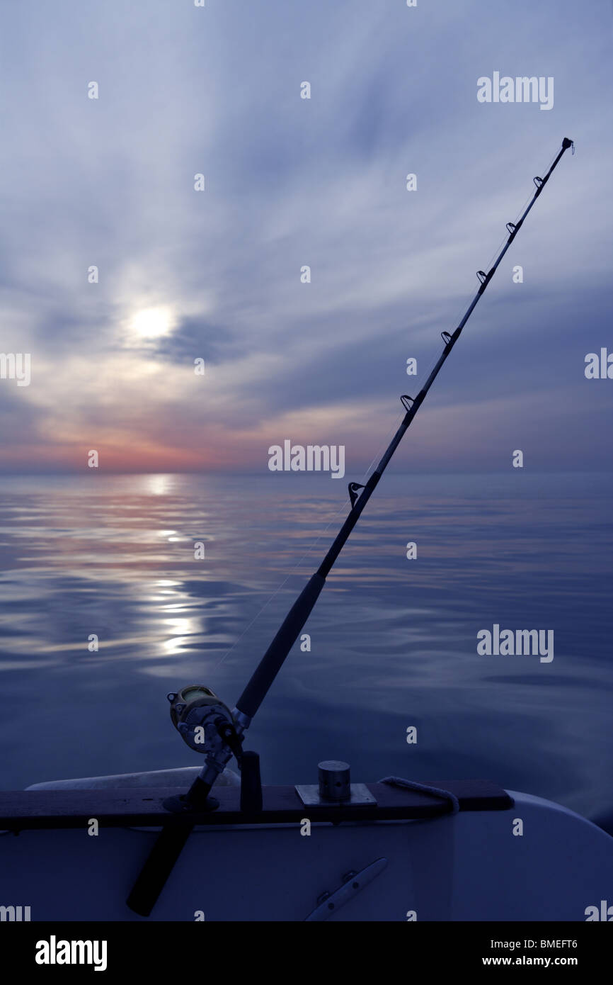 boat fishing sunrise on sea ocean rod and reels horizon Stock Photo - Alamy