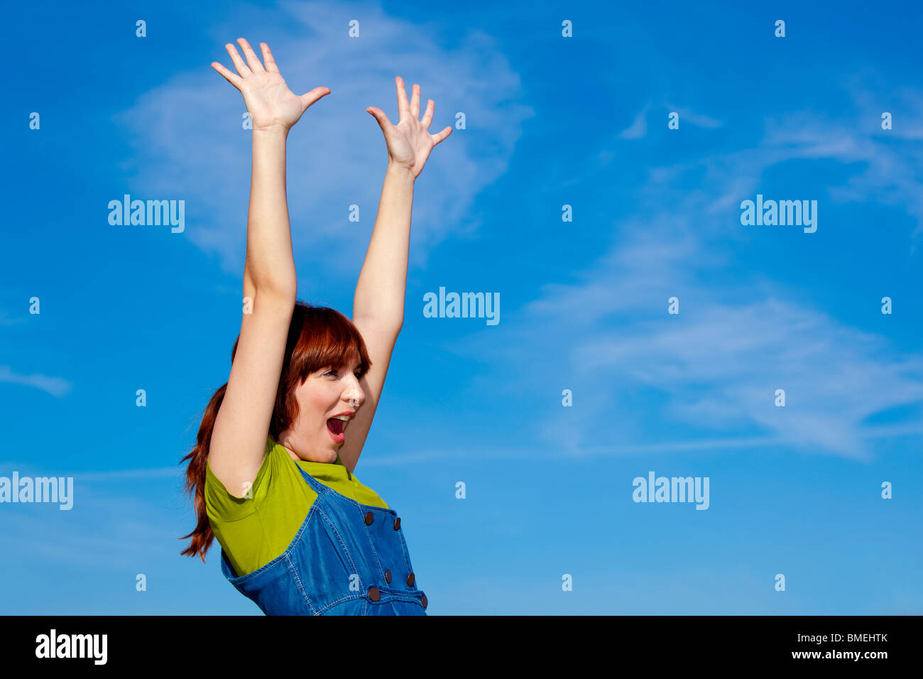 Portrait of a beautiful woman over a blue sky with arms open Stock ...