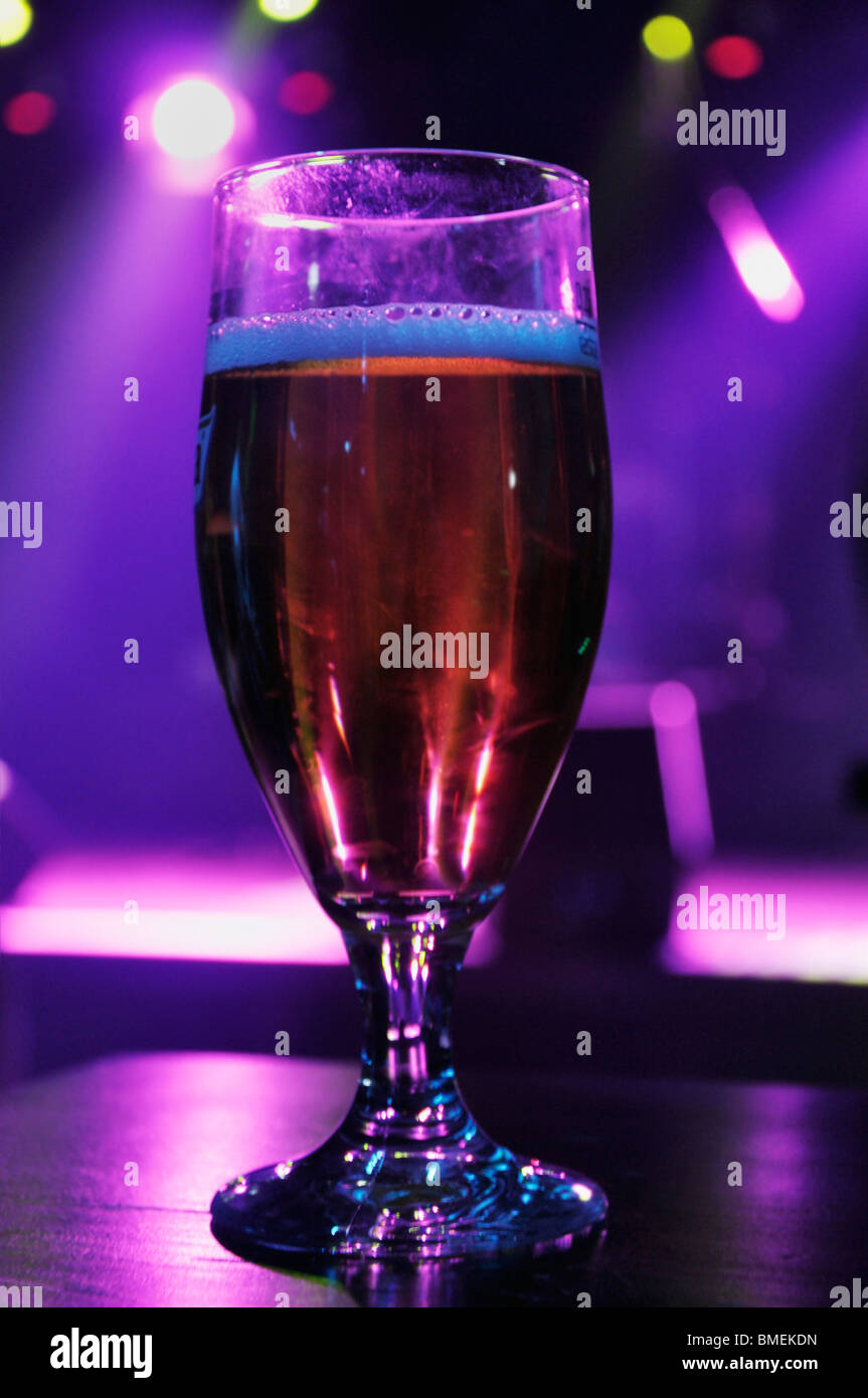 Glass of beer at night club table Stock Photo - Alamy
