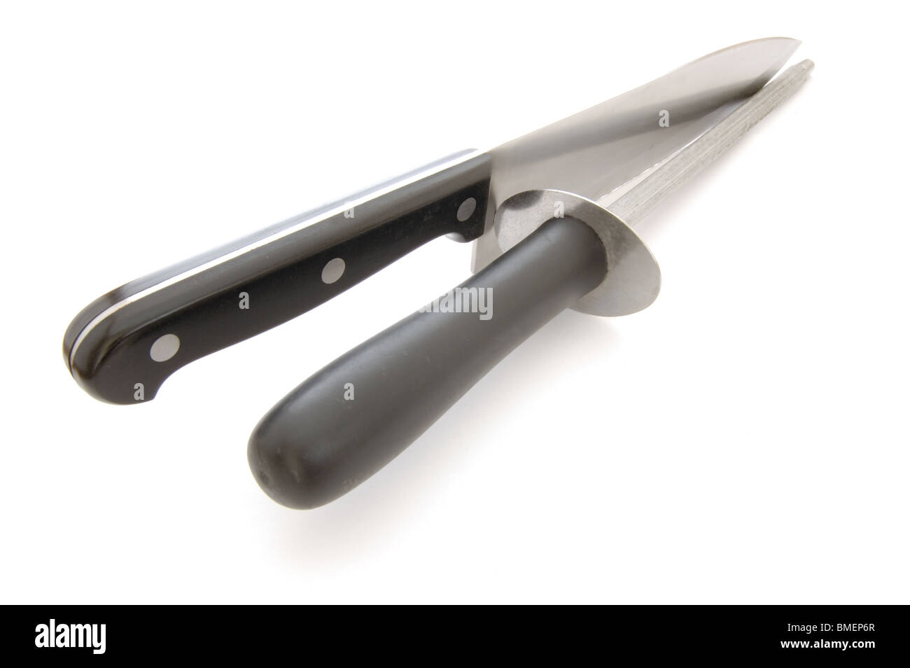 Stainless steel kitchen knife and sharpener isolated on a white ...