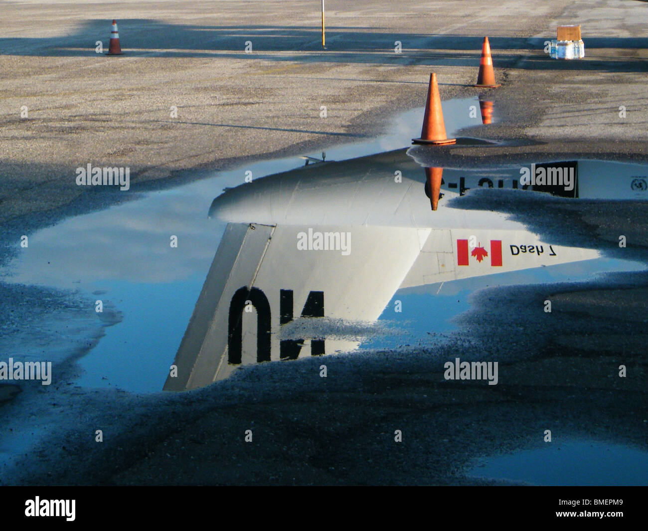 A Canadian United Nations plane is reflected in a puddle on the runway ...