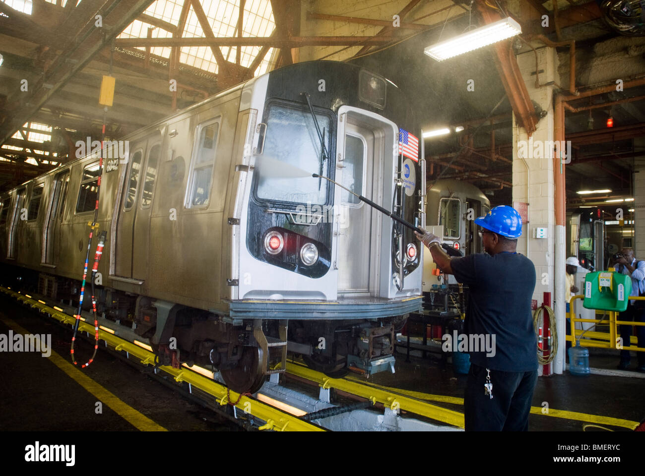 A transit employee cleans the bonnet of subway car in the car wash of ...