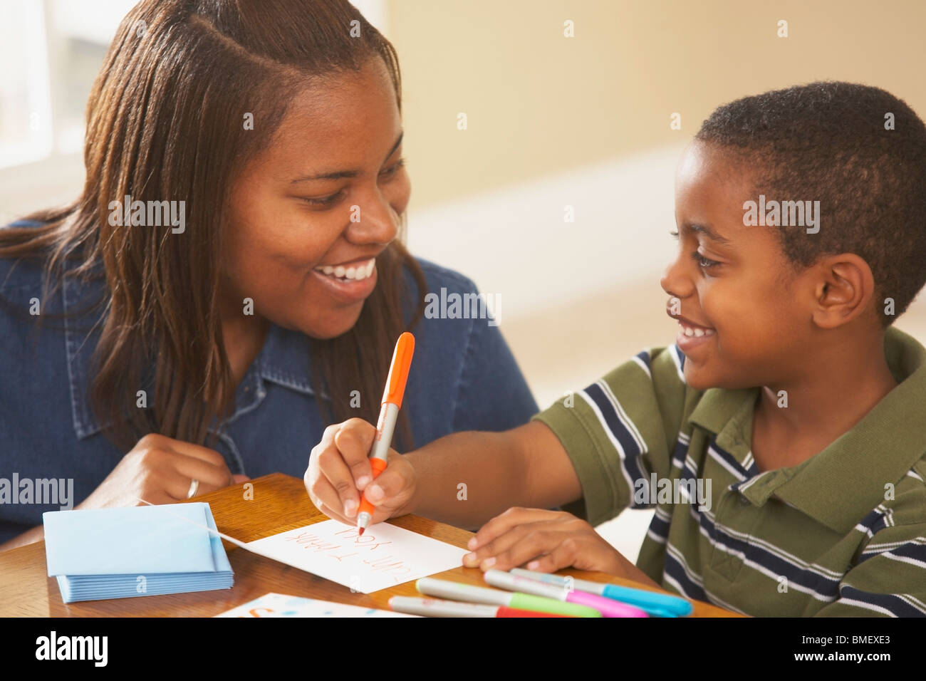 A Boy Writing Cards With His Mother Stock Photo - Alamy