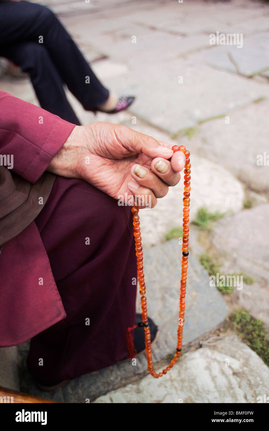 Hand of a monk holding prayer beads, Luohou Temple, Mount Wutai ...