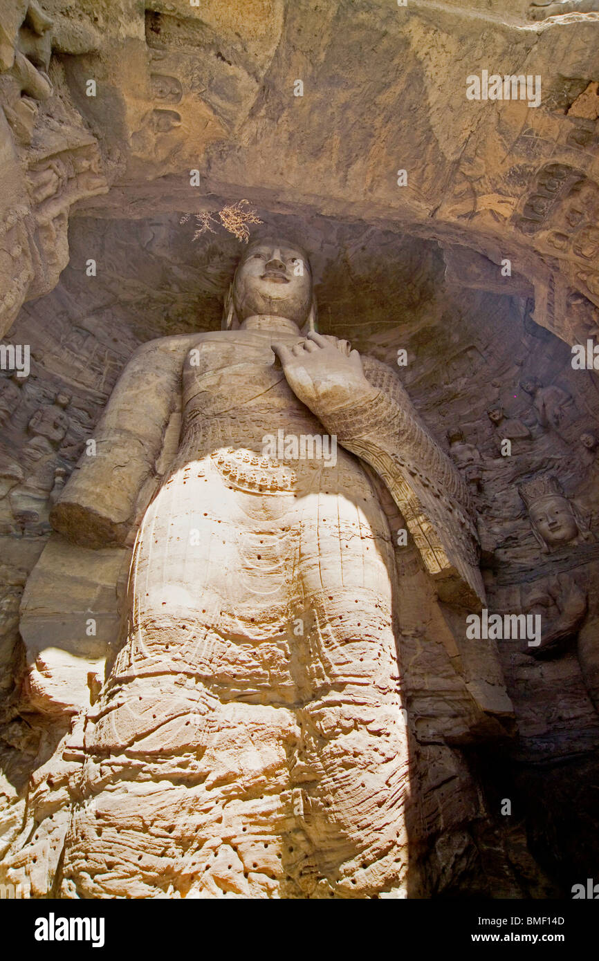 Damaged statue of standing Buddha in cave, Yungang Grottoes, Datong ...