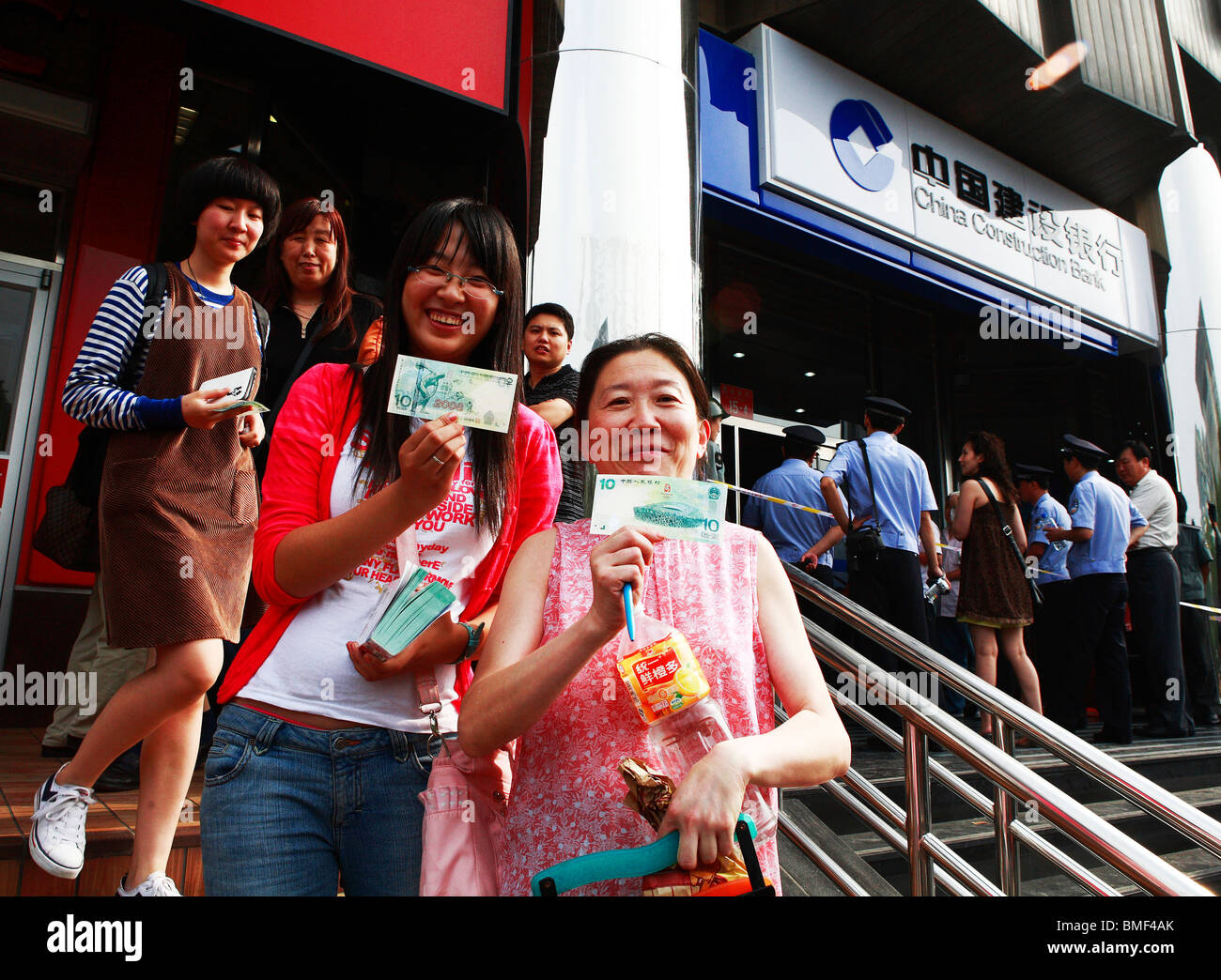 Chinese women displaying new 10 RMB Beijing Olympic Commemorative note ...