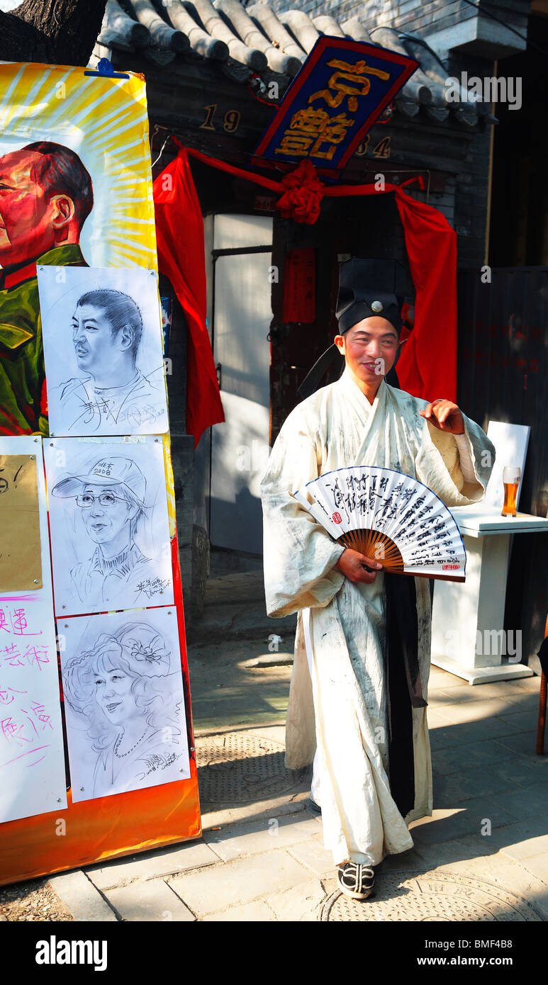 Folk artisan in Chinese traditional costume displaying his artwork ...