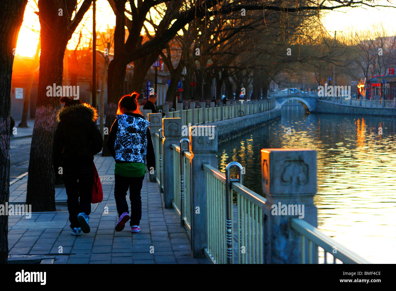 Girls walking along Houhai Lake in sunset, Beijing, China Stock Photo ...