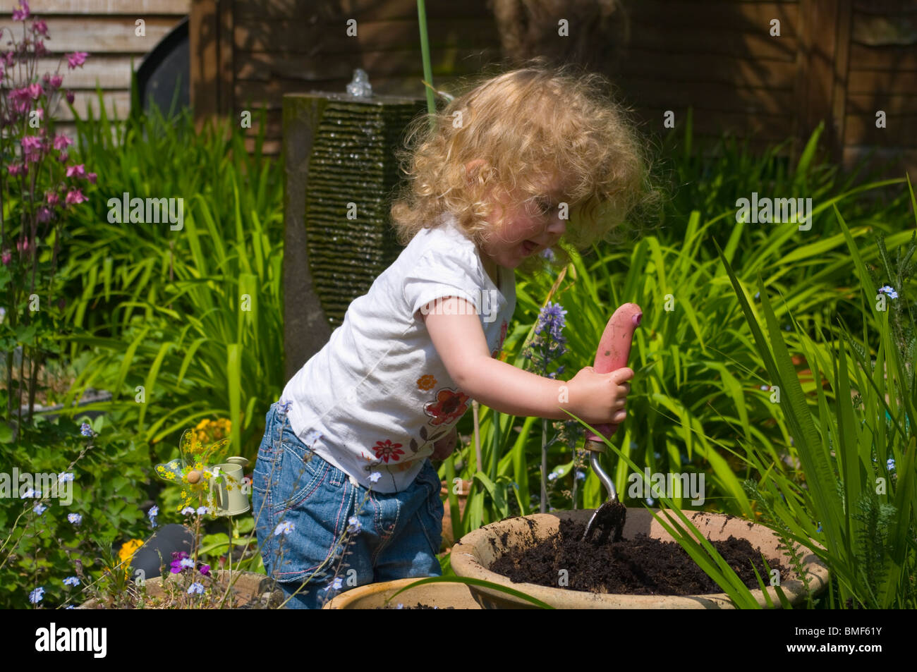 Young Child Digging With A Garden Fork In A Large Flower Pot In The ...