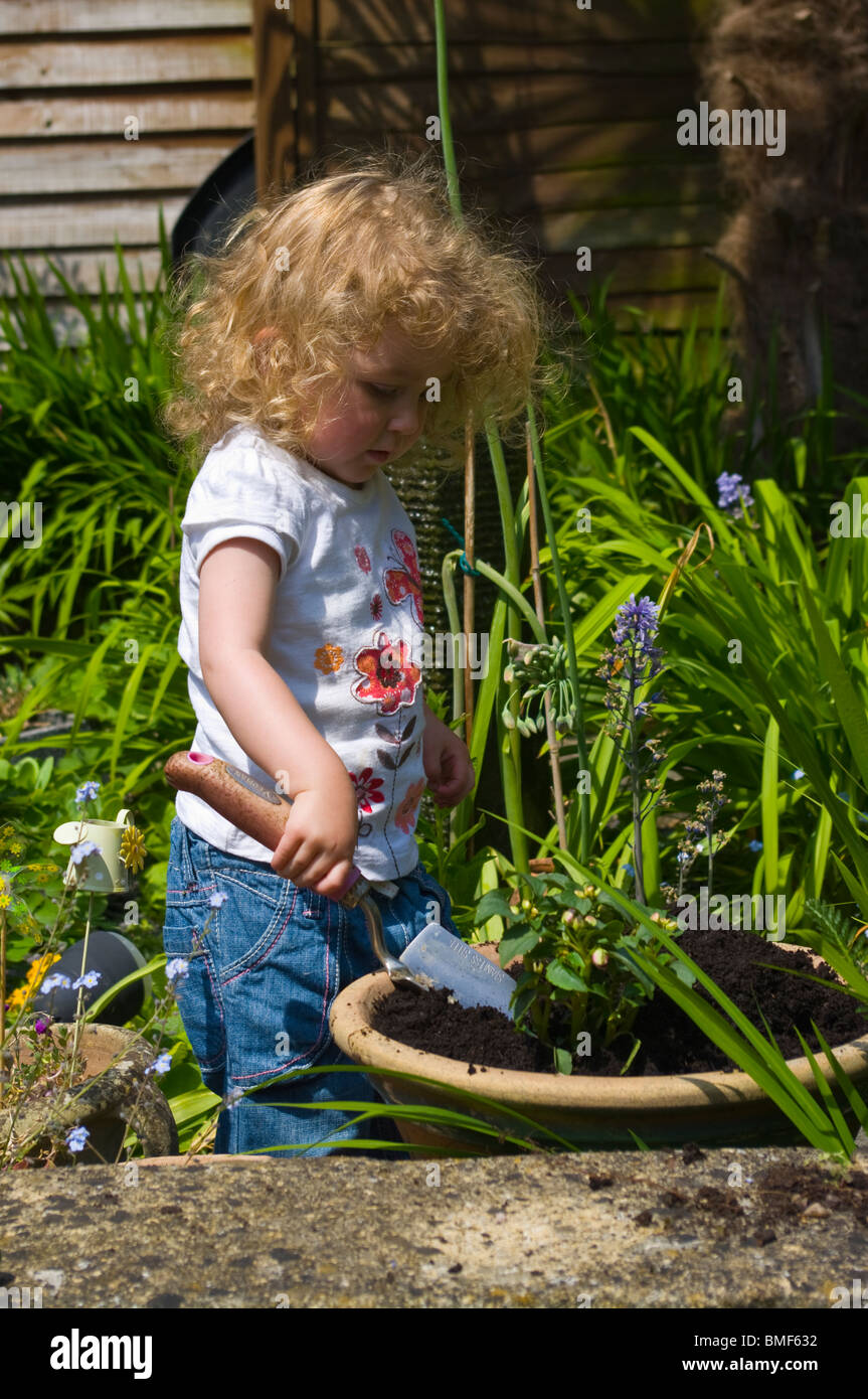 Young Child Digging With A Garden Trowel In A Large Flower Pot In The ...