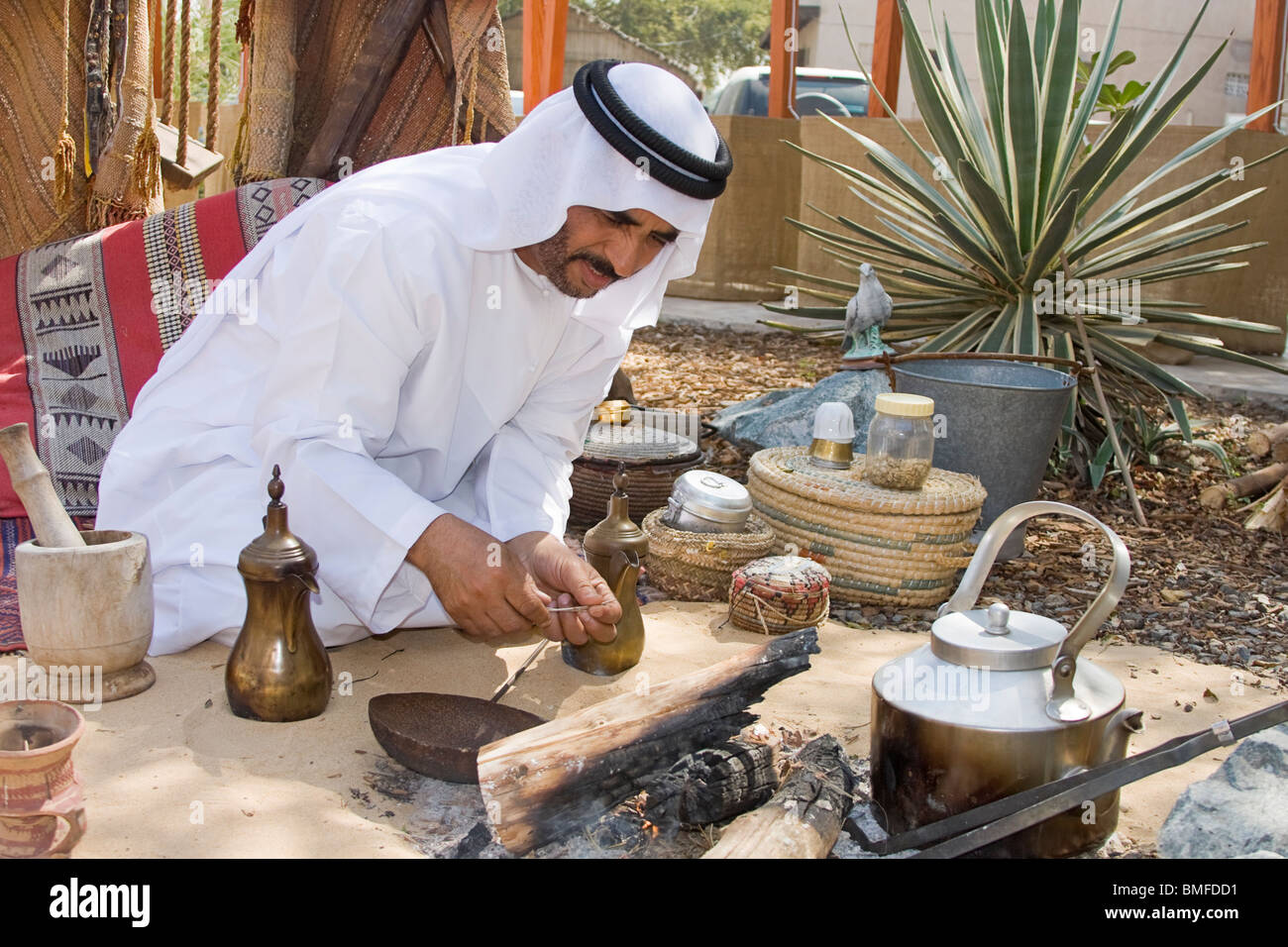Arab man in typical Arab dress shows how coffee was roasted before ...