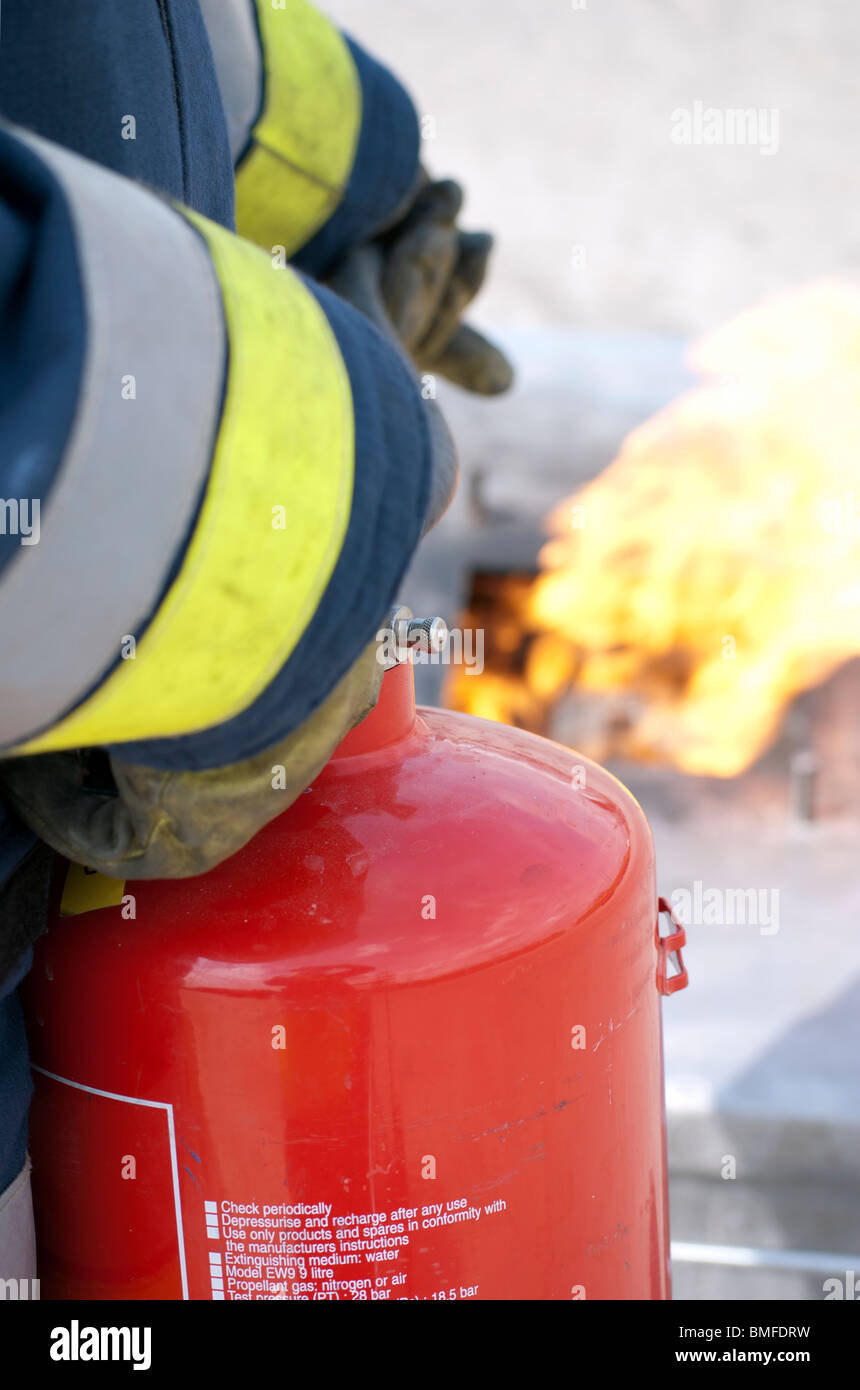 firefighter tackling a small fire Stock Photo - Alamy