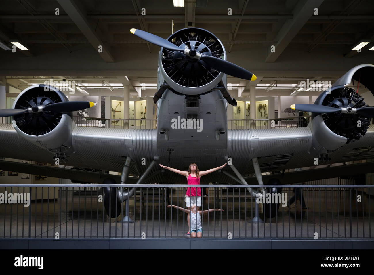Two young girls play at flying under a Junkers Ju 52/3m trimotor plane ...