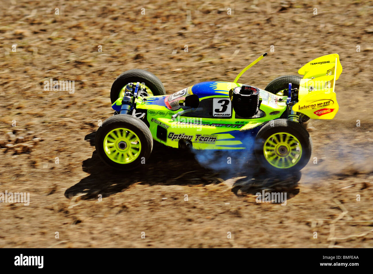 A model racing car accelerating away from a jump on a dirt track ...