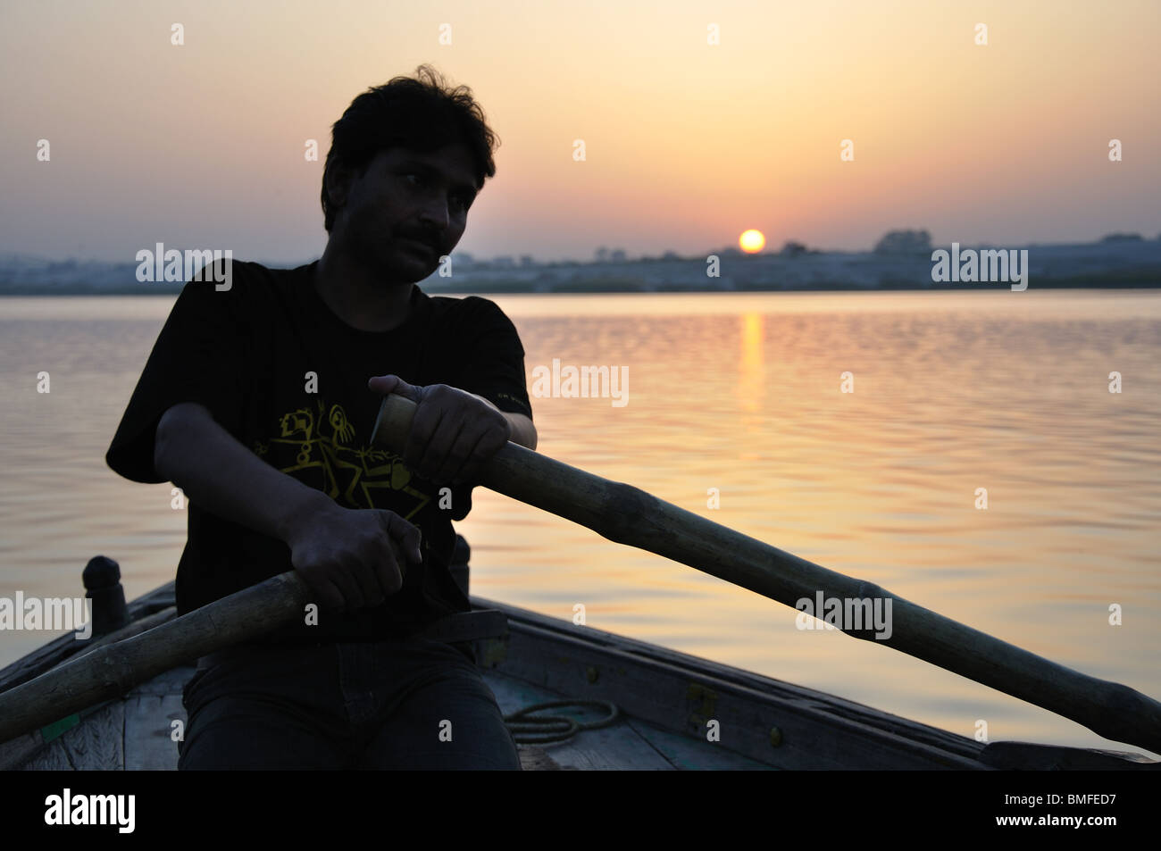 Man rowing a boat at dawn on the River Ganges, Varanasi, India Stock ...