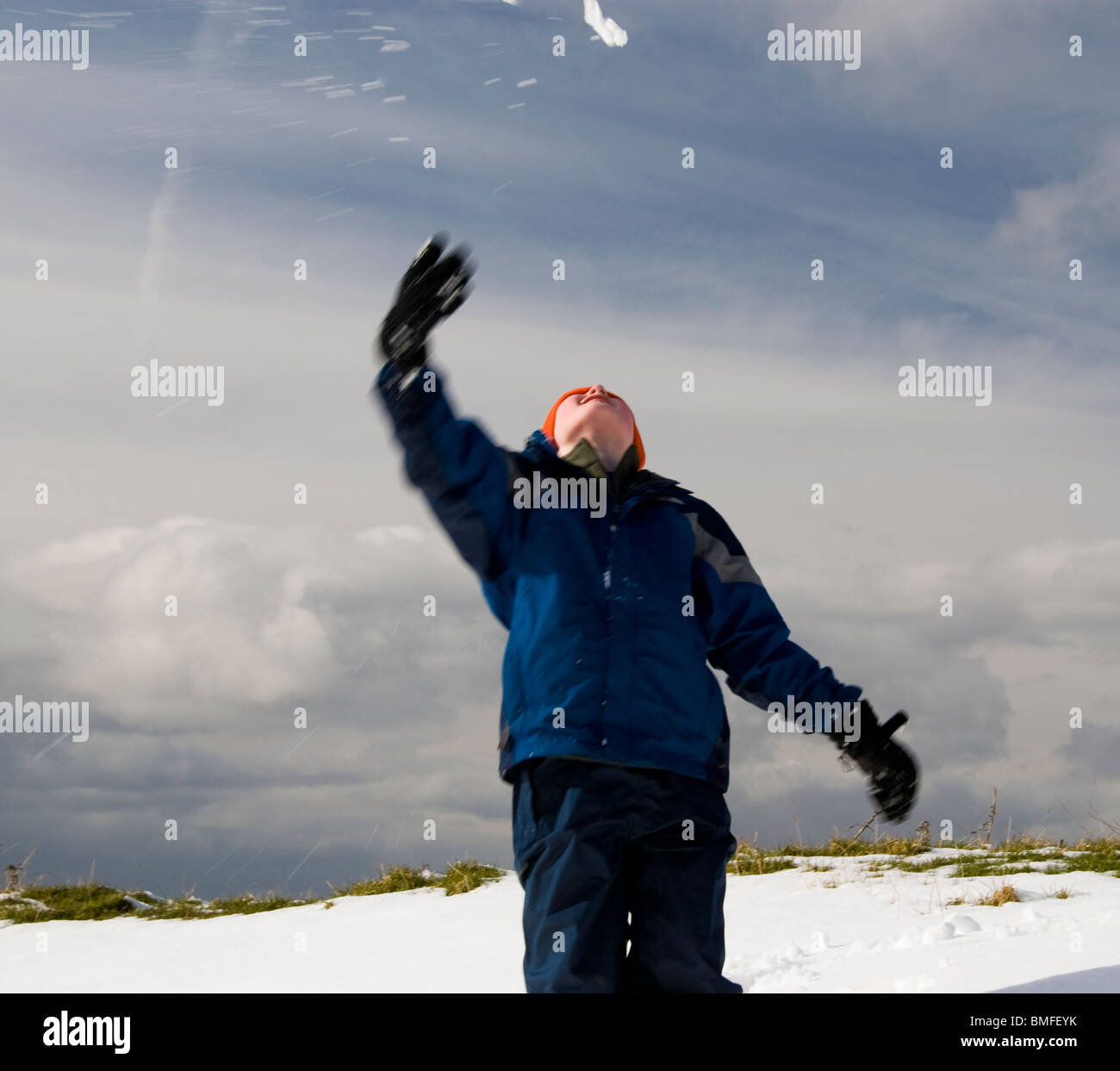 Boy throwing snowball into sky Stock Photo - Alamy