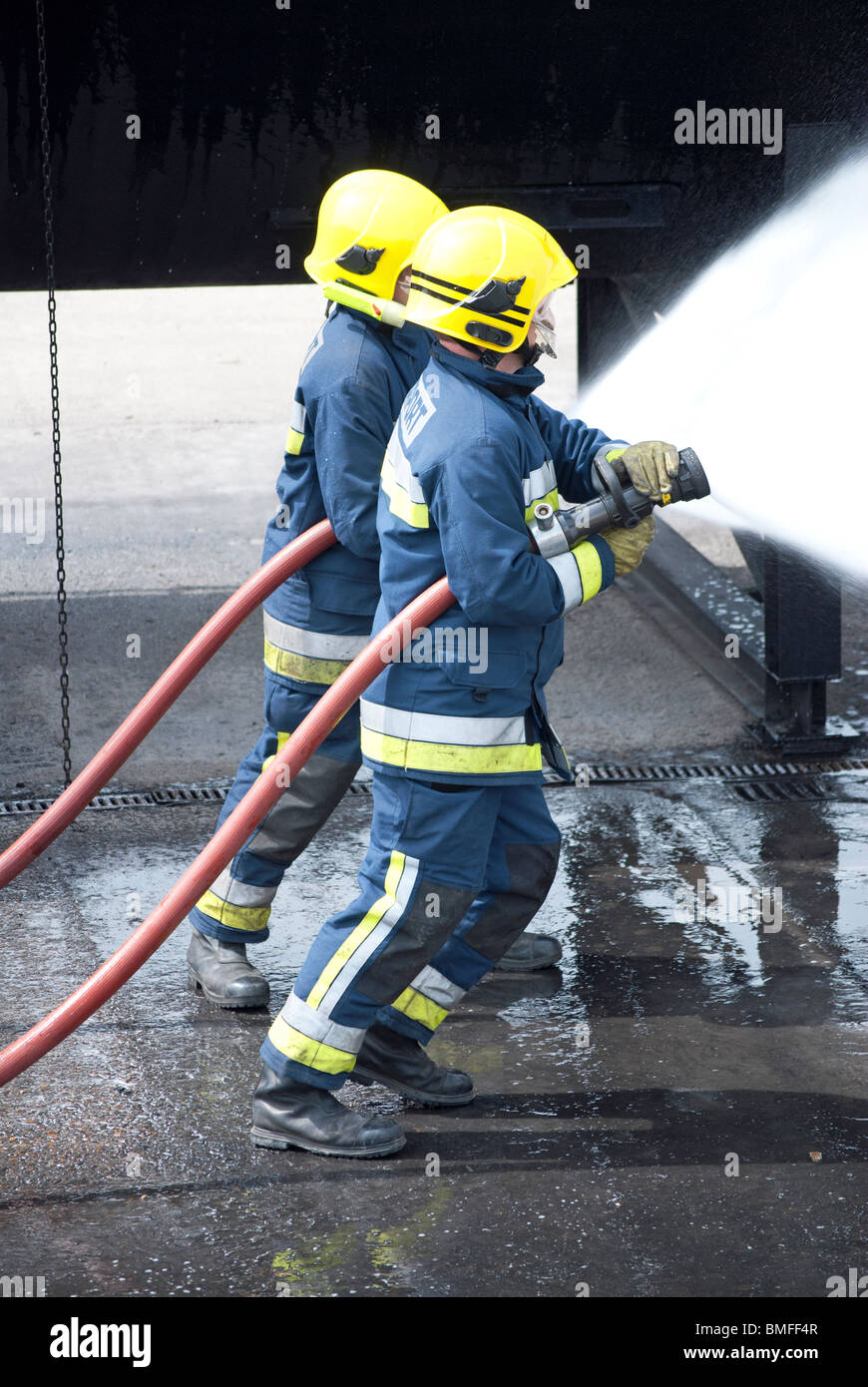 Firemen using hose hi-res stock photography and images - Alamy