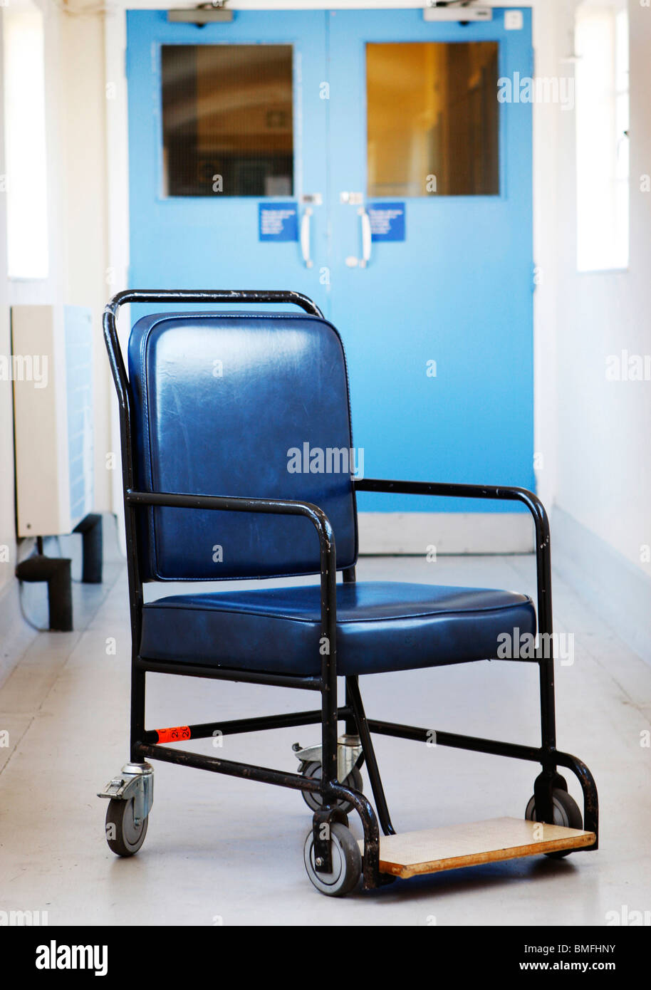 An empty wheelchair sitting in the middle of a hospital corridor Stock ...