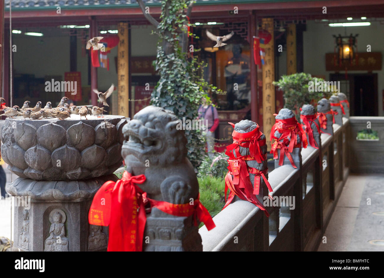 Stone lion railing covered with red prayer ribbon, Jade Buddha Temple ...