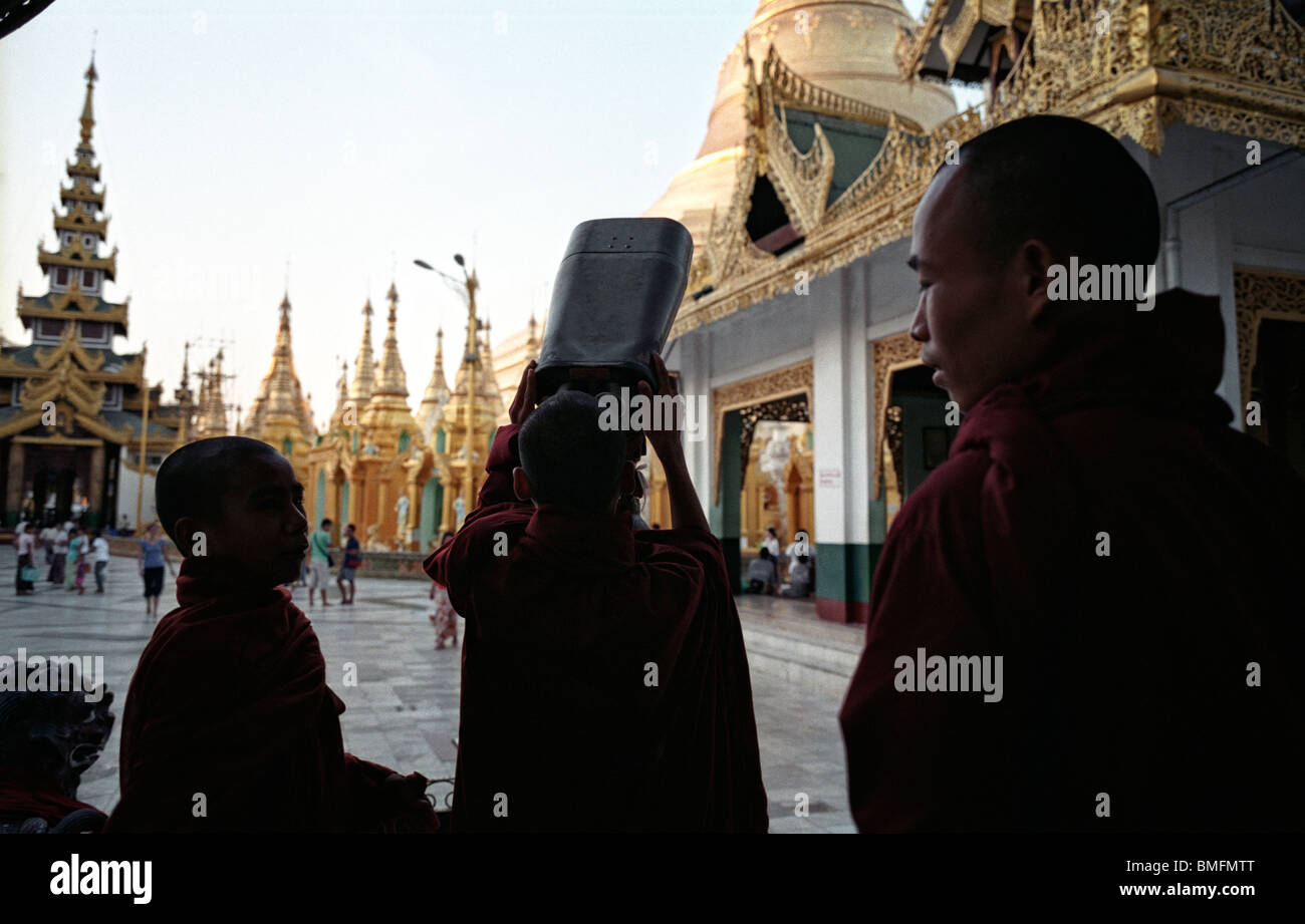 Young monks look up at the the Shwedagon Pagoda through binoculars in ...